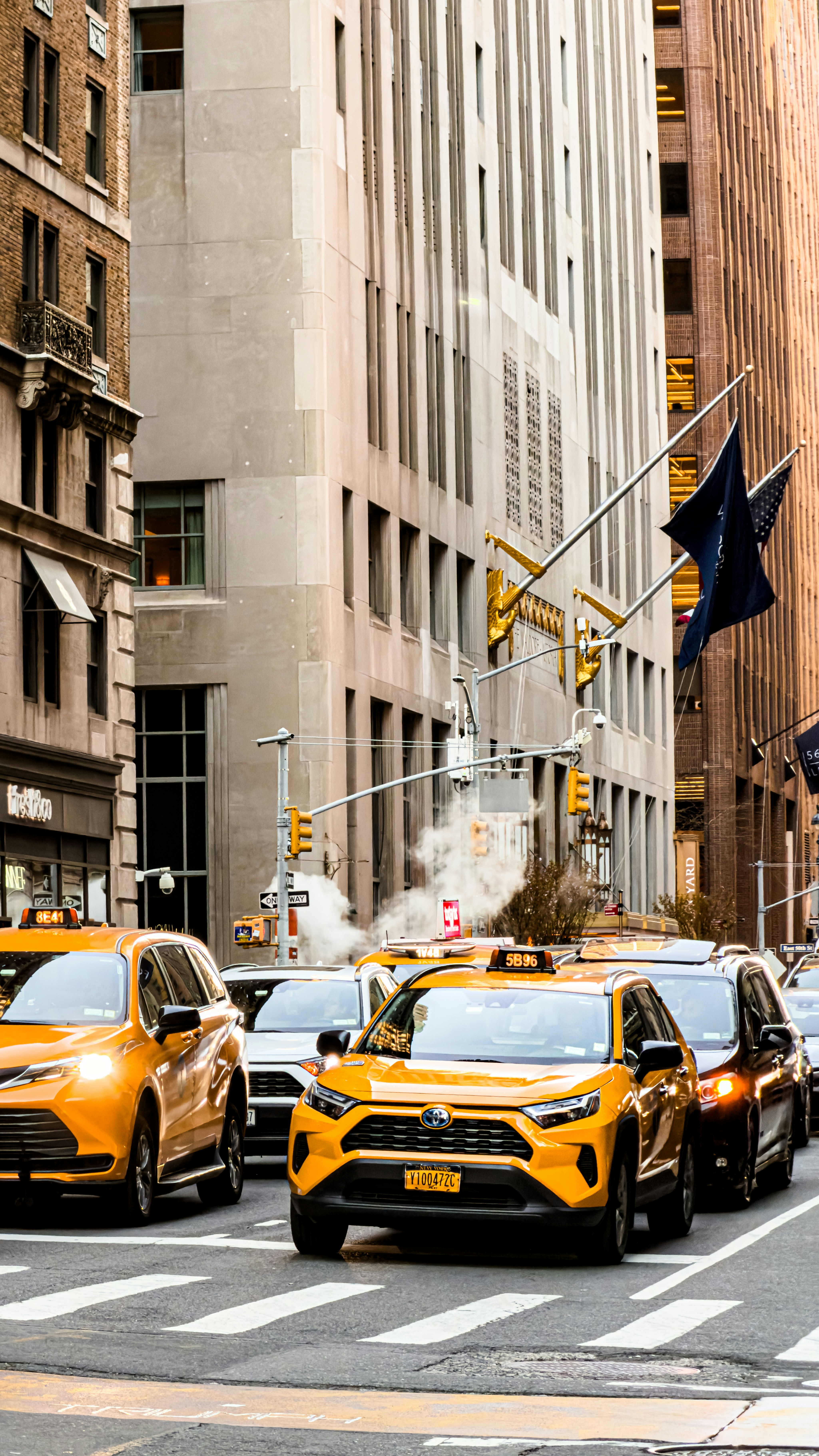 City Taxi Parade: Golden Cabs March Through Concrete Canopy