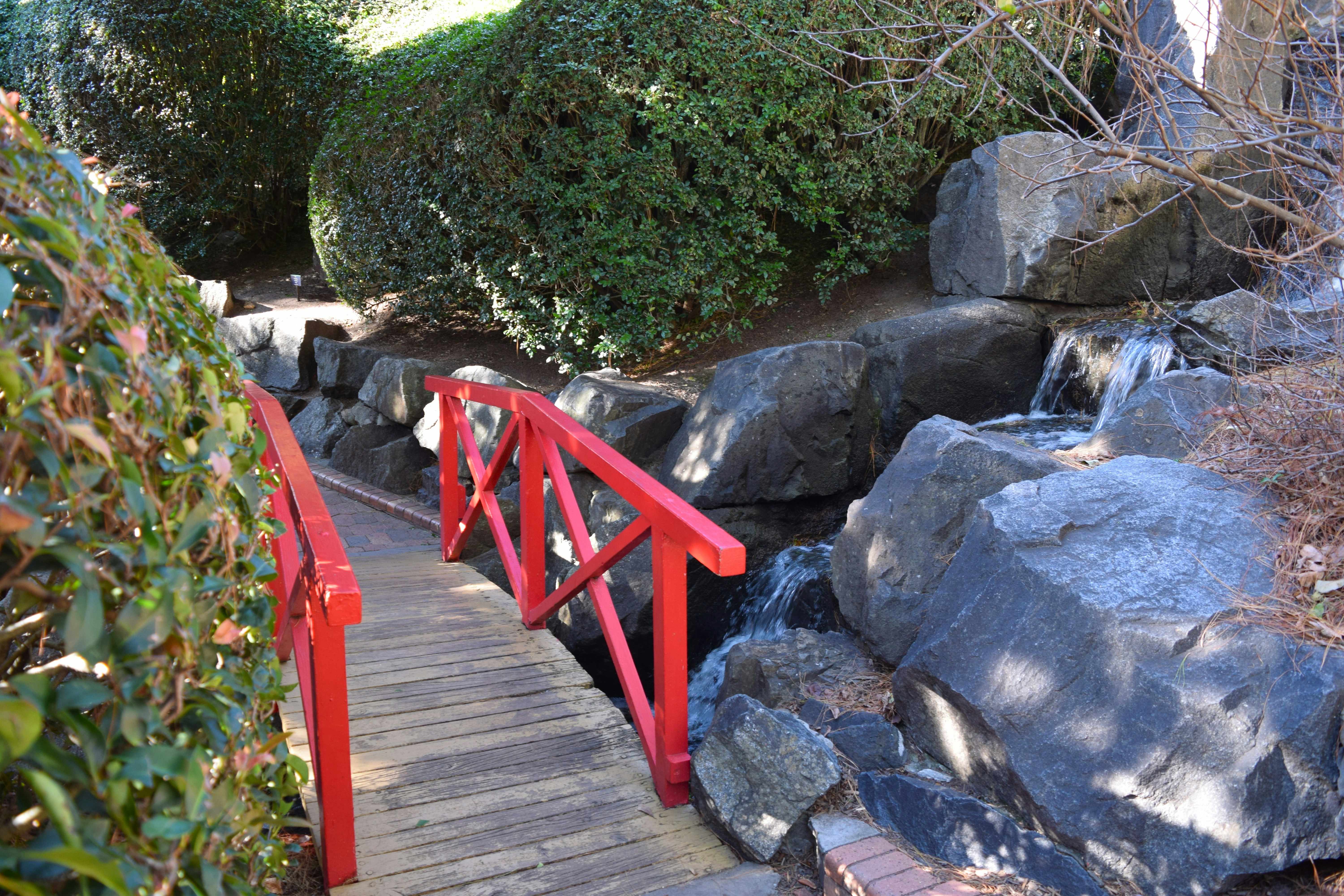 Red bridge among stones: a tranquil garden crossing
