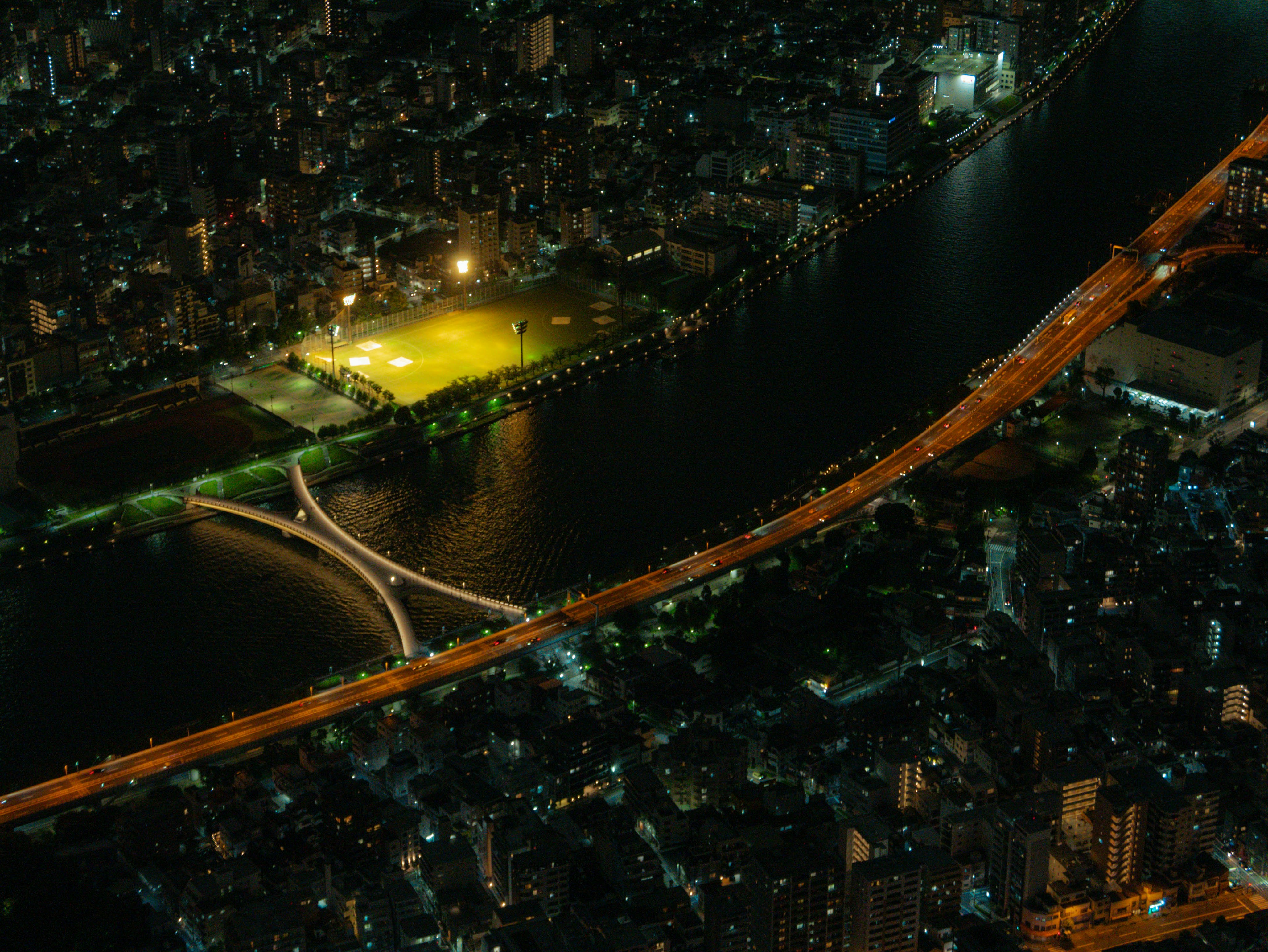 Nighttime Arc: A City Bridge weaves through glowing riverfront streets