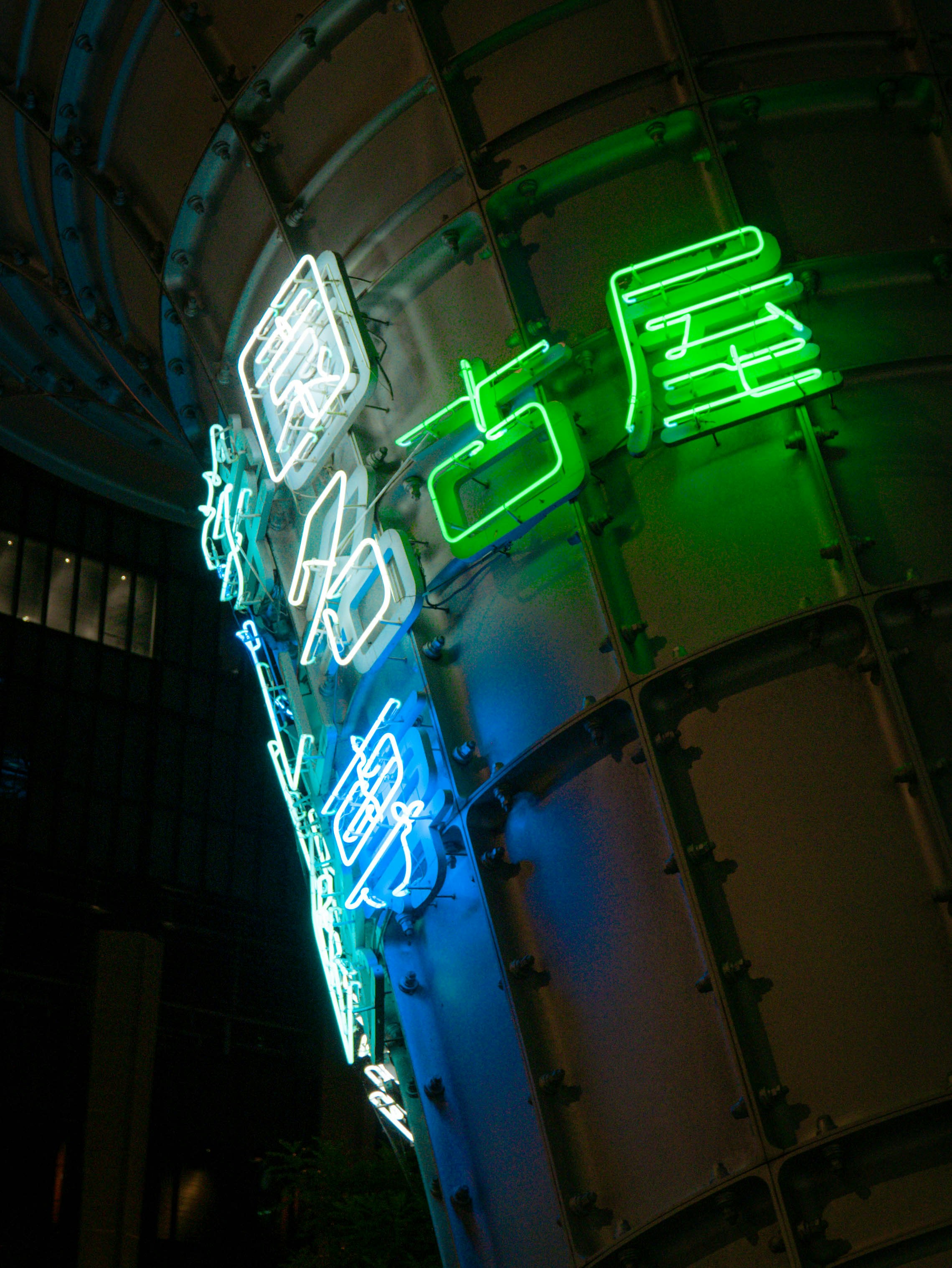 Neon Night Sign on a Curved Urban Facade
