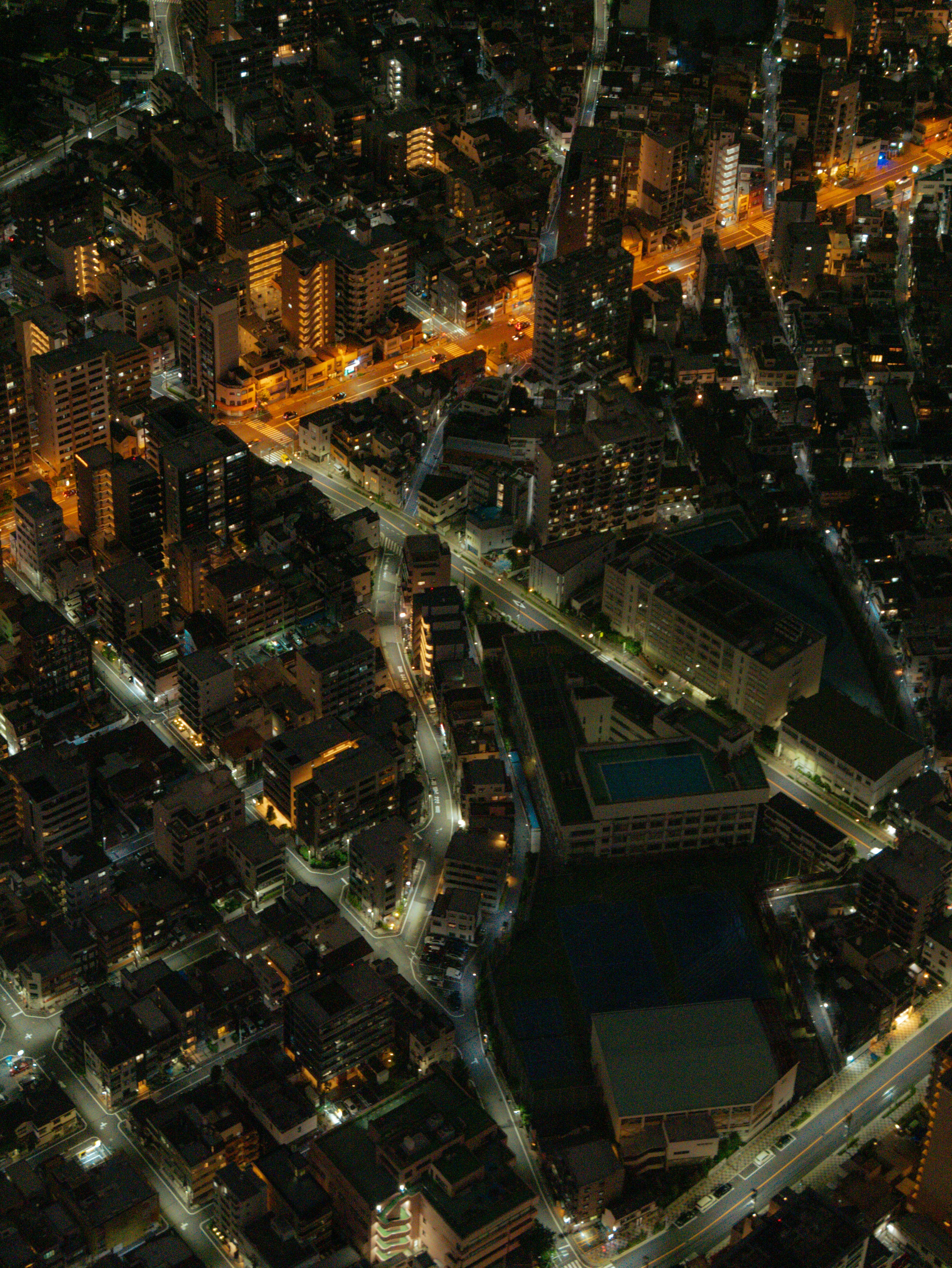 Aerial Pulse: Nighttime Ribbon of Streets through a Dense City