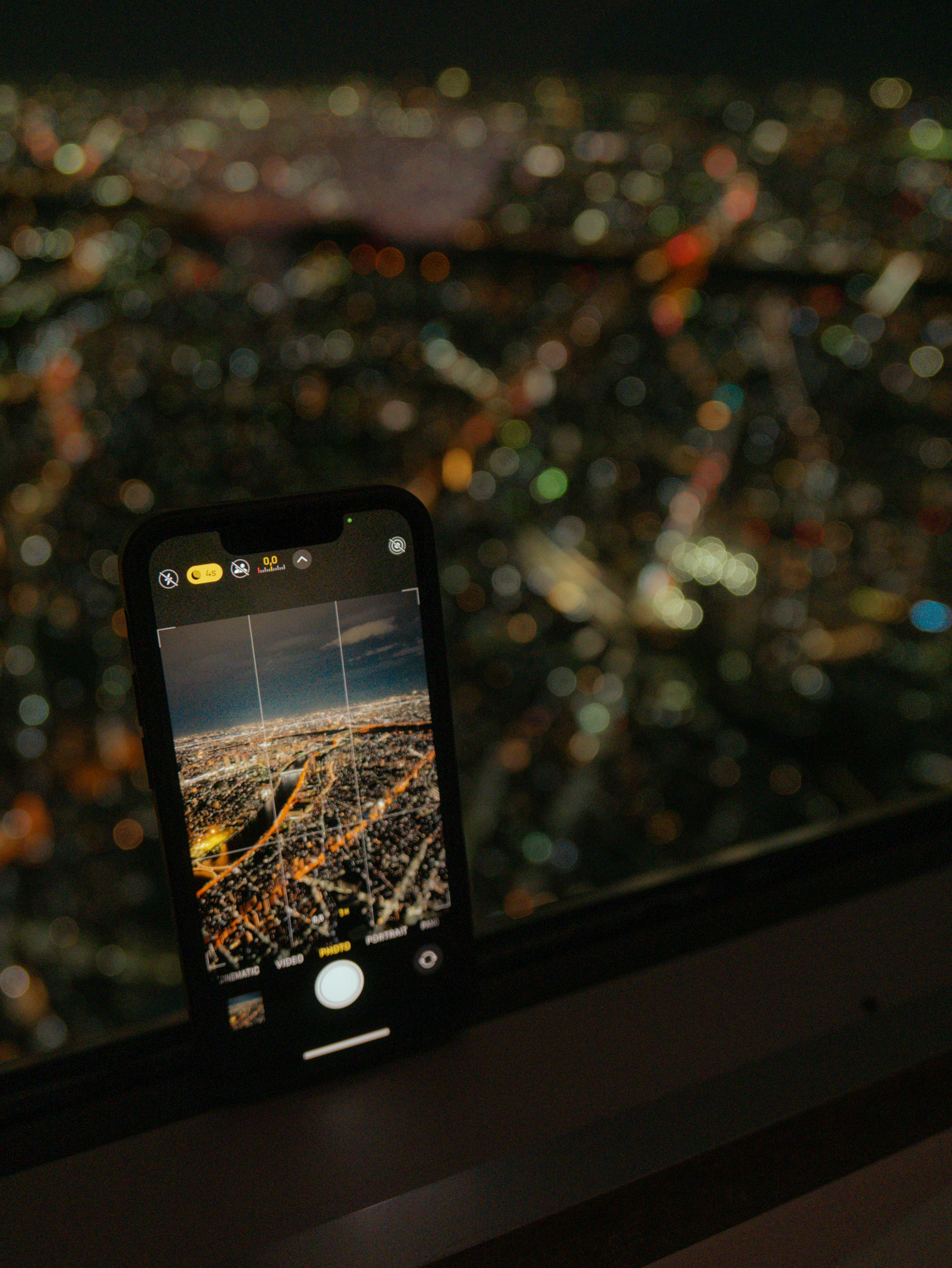 Night City on a Phone Screen: Bokeh Lanterns Behind a Shuttered View