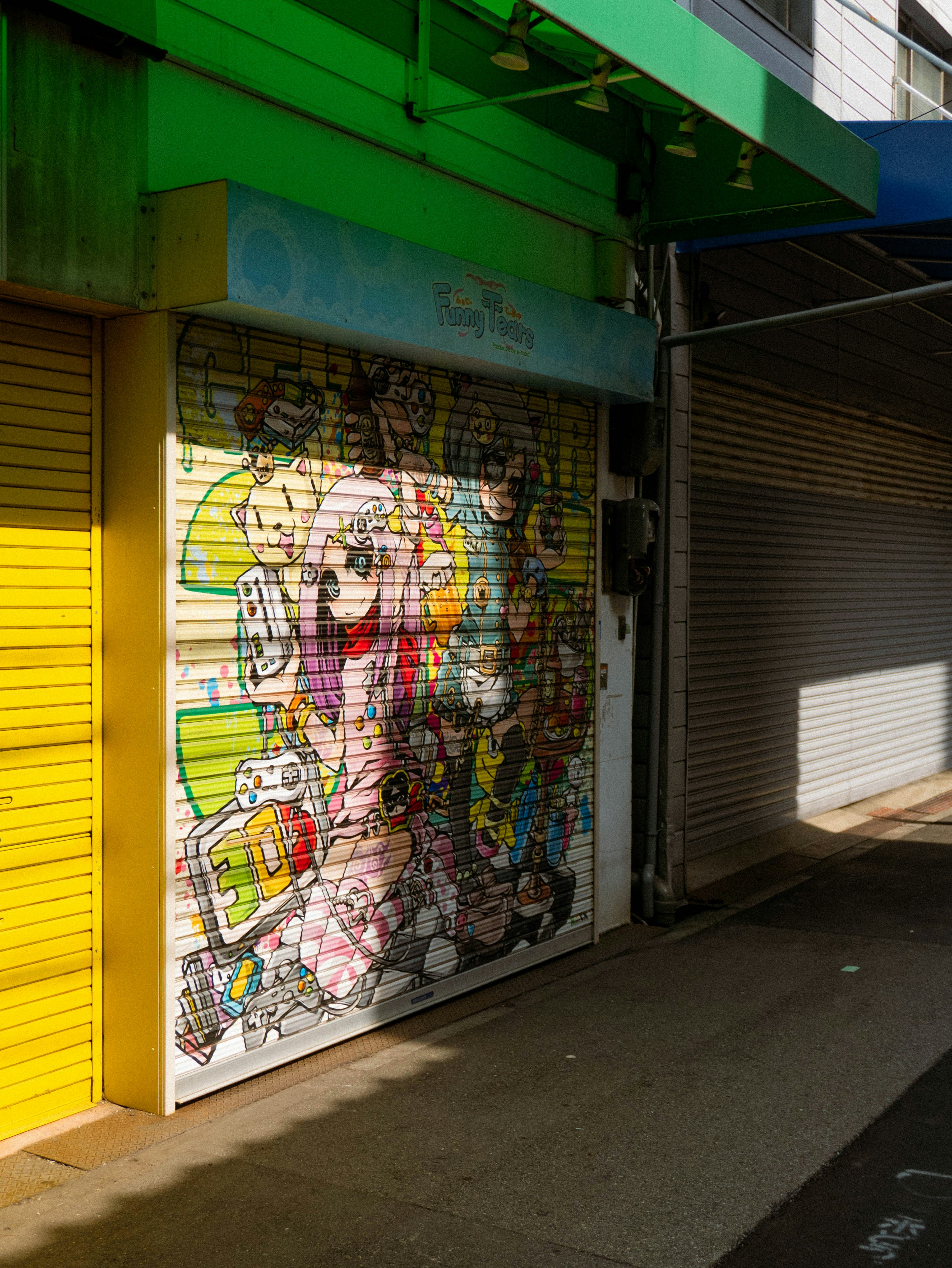 Graffiti storefront mural under a sunlit awning