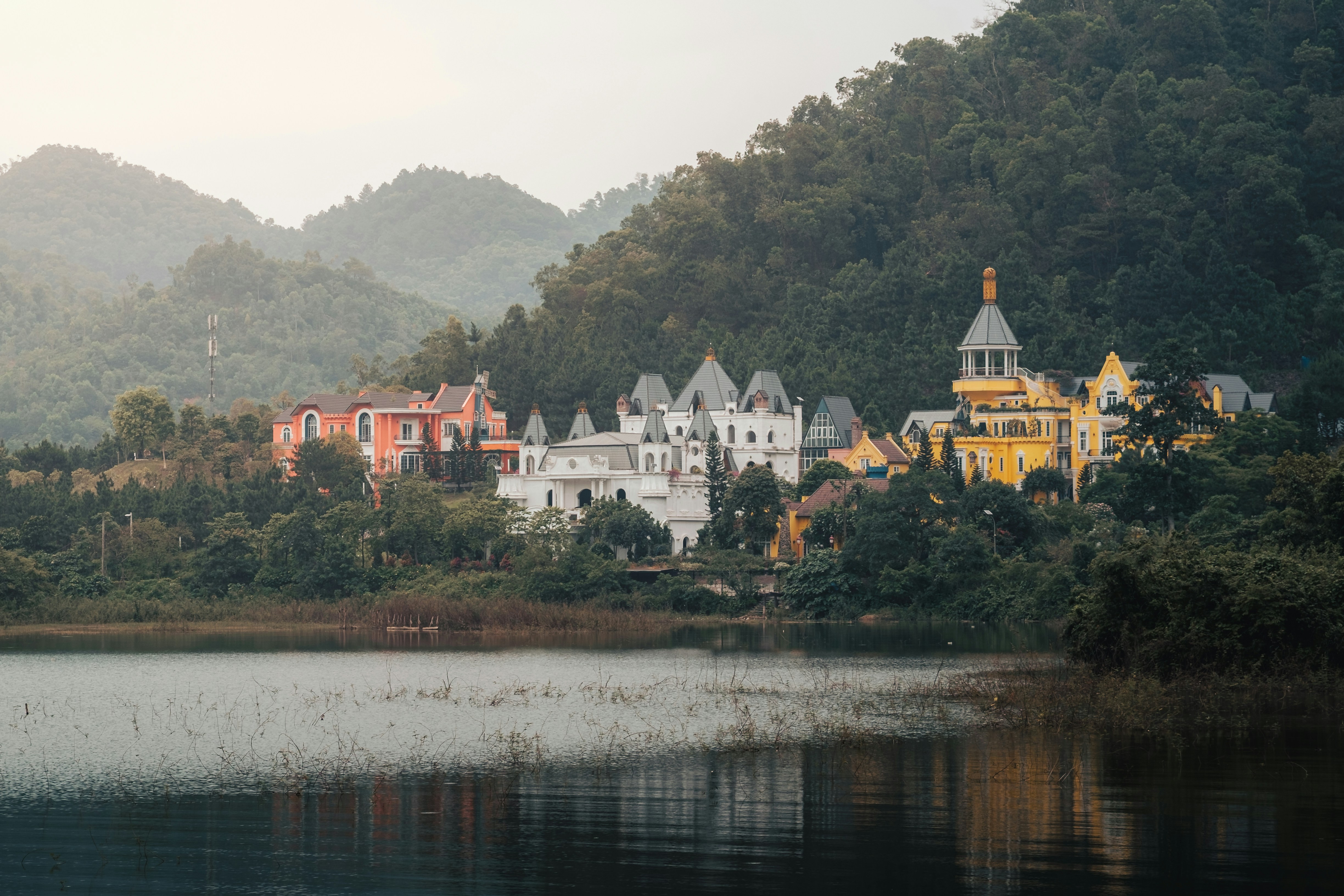 Colorful hillside village reflected on a tranquil lake