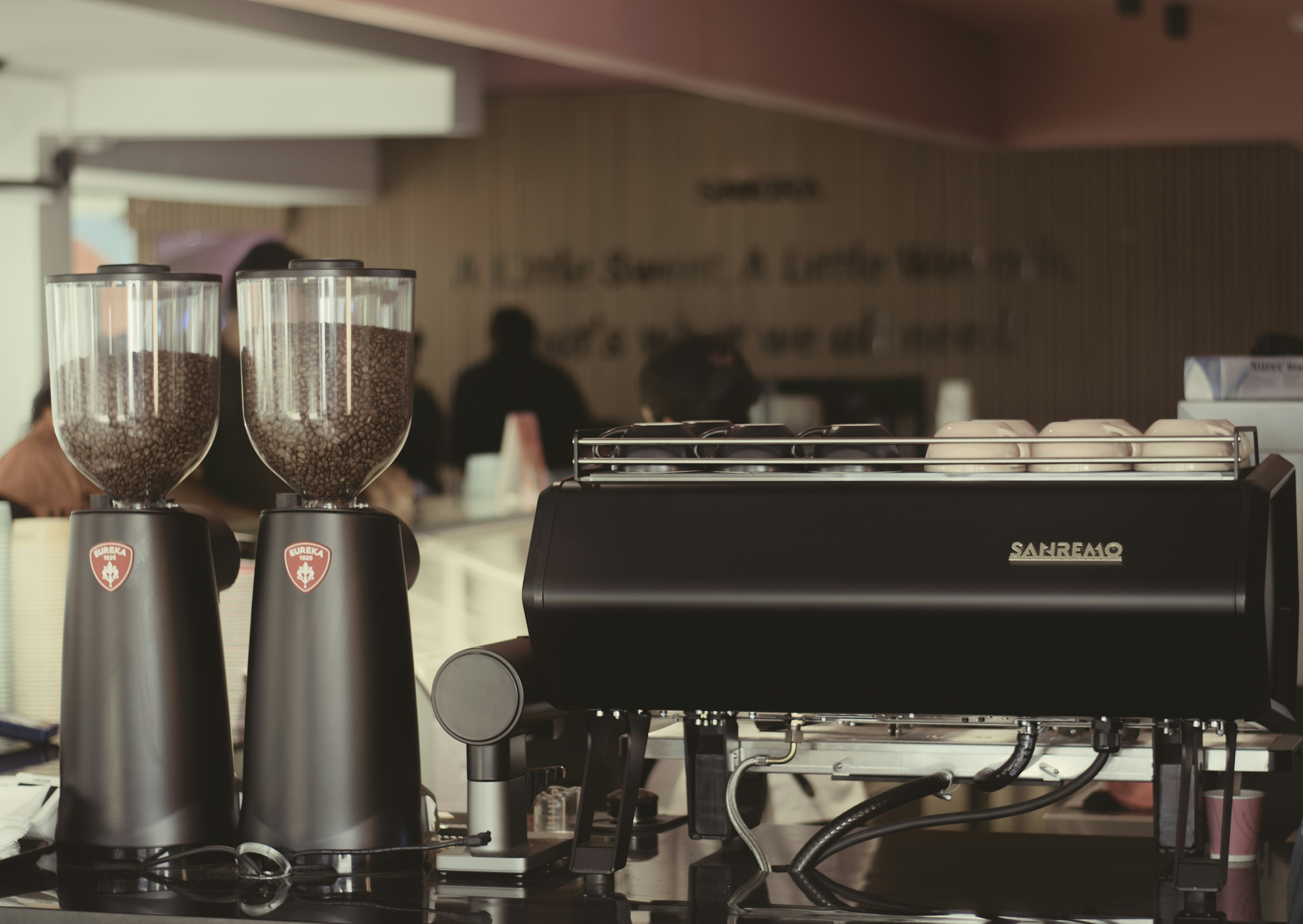 Cafe Baristas and Espresso Machine in Focus