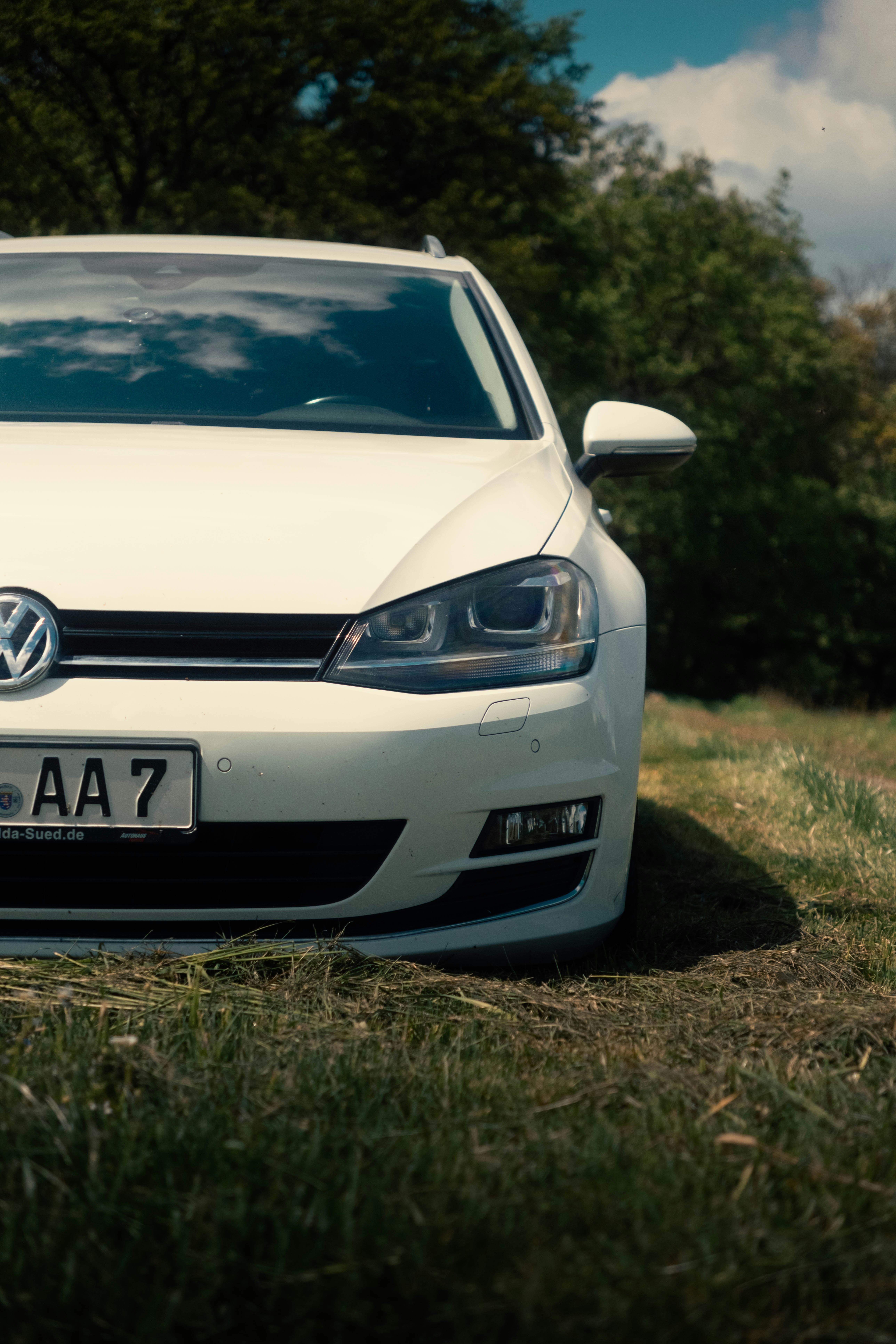 Front-Quarter Calm: A White VW Rest in Sunlit Field