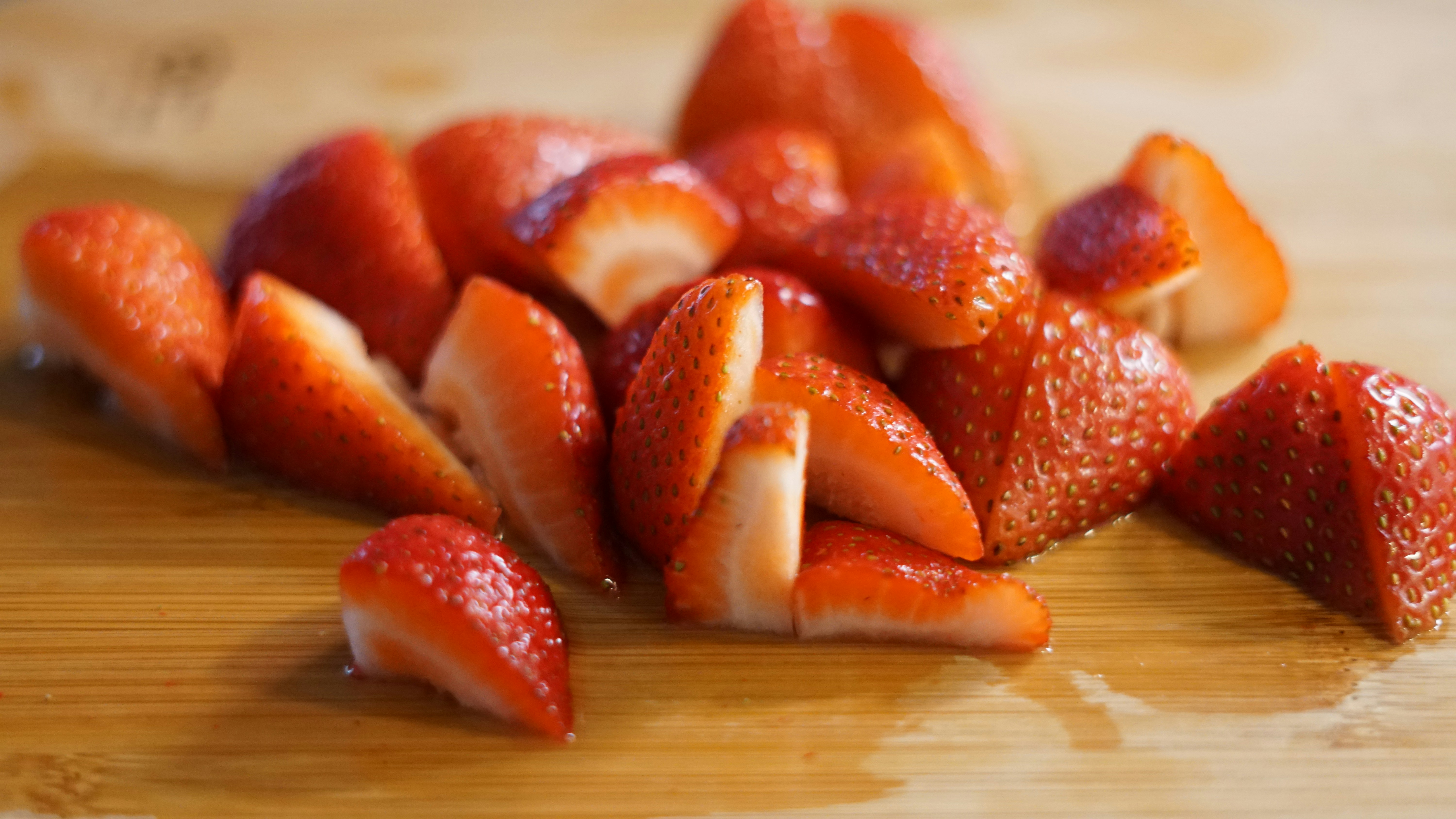 Ripe Strawberry Fragments on a Light Wooden Board