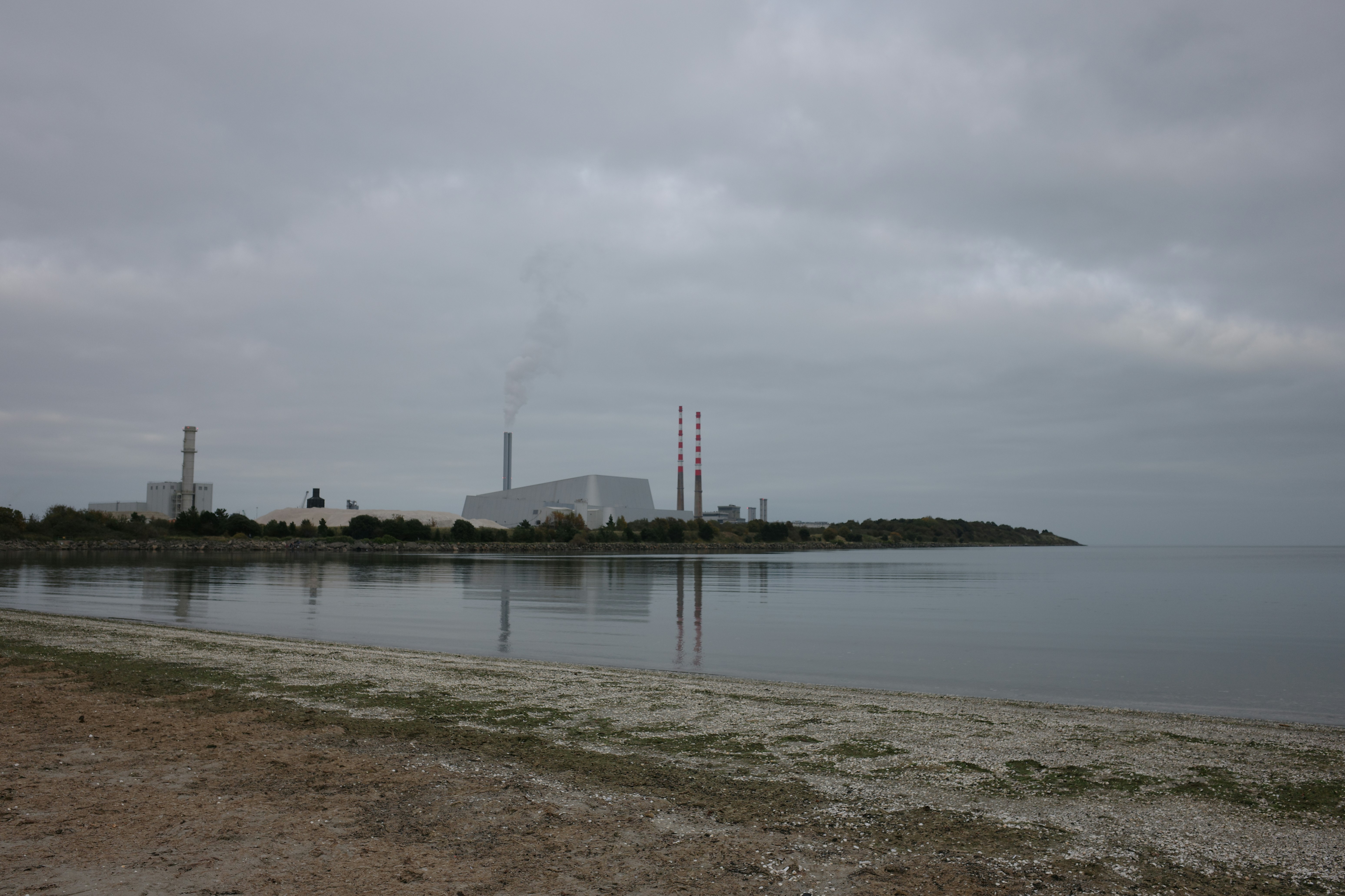 Industrial Horizon: Quiet Coastline with Power Plant