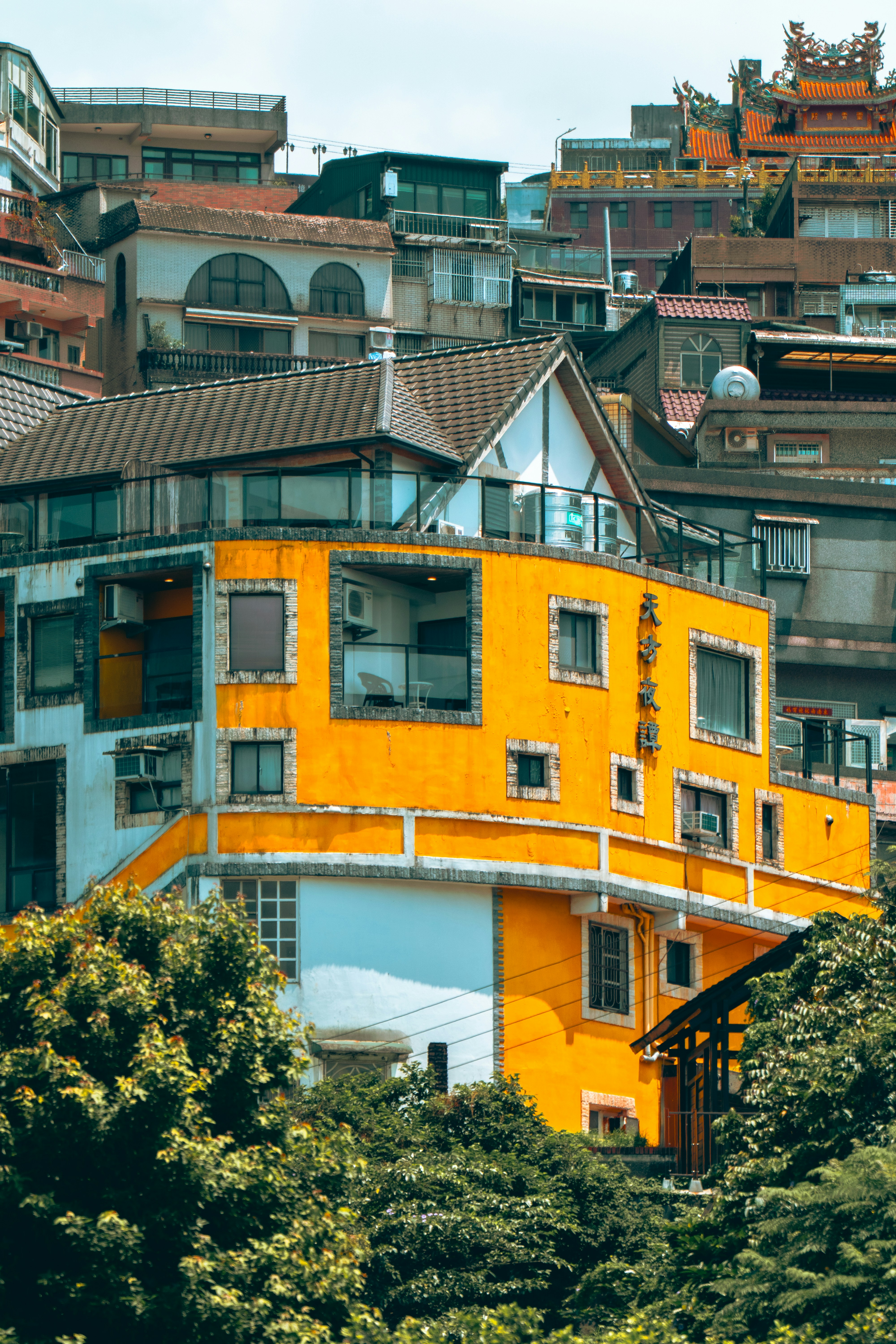 Urban Mosaic: The Bright Orange Corner Building Among Terraced Rows