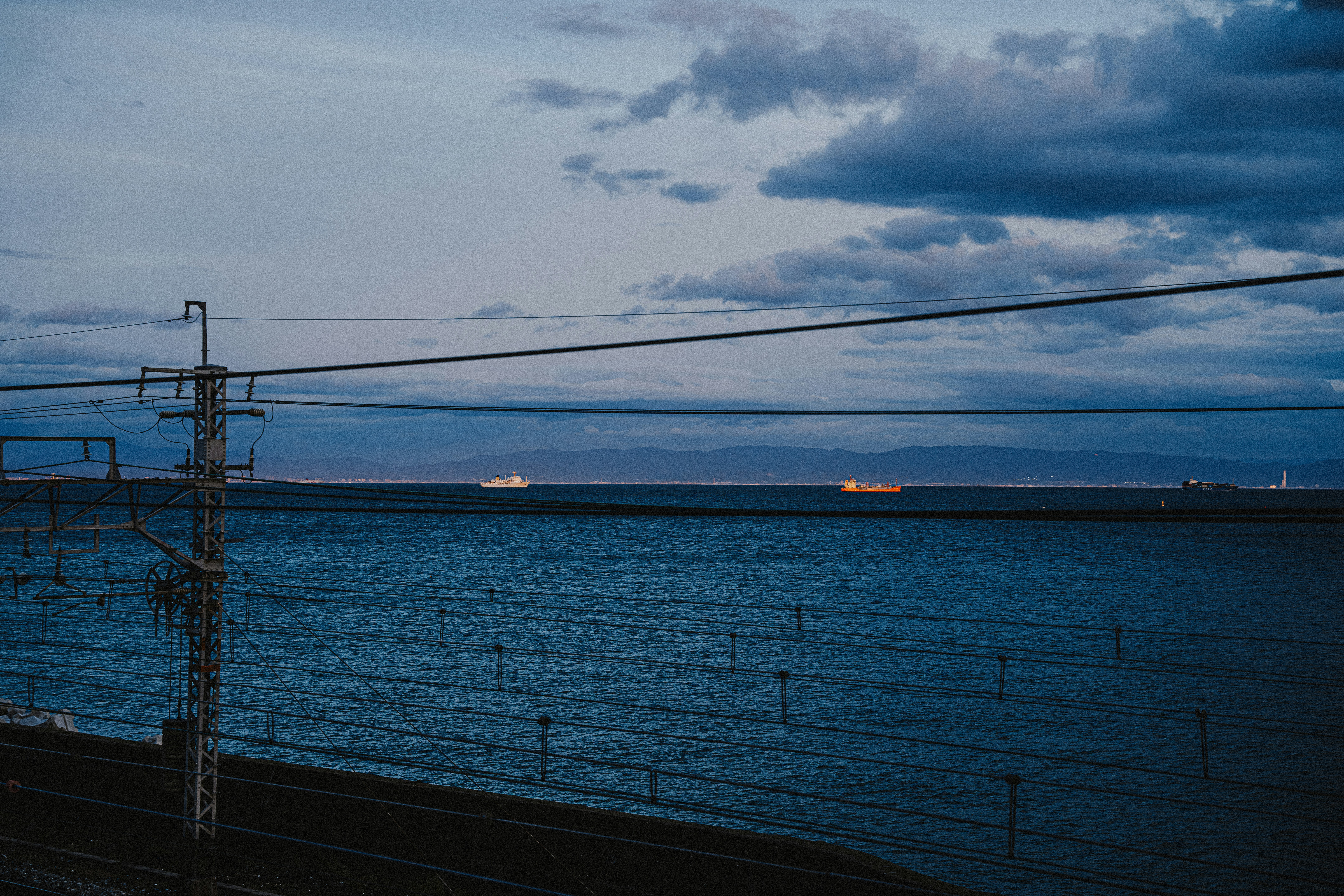 Cotton‑blue Horizon over a Quiet Coastal Line