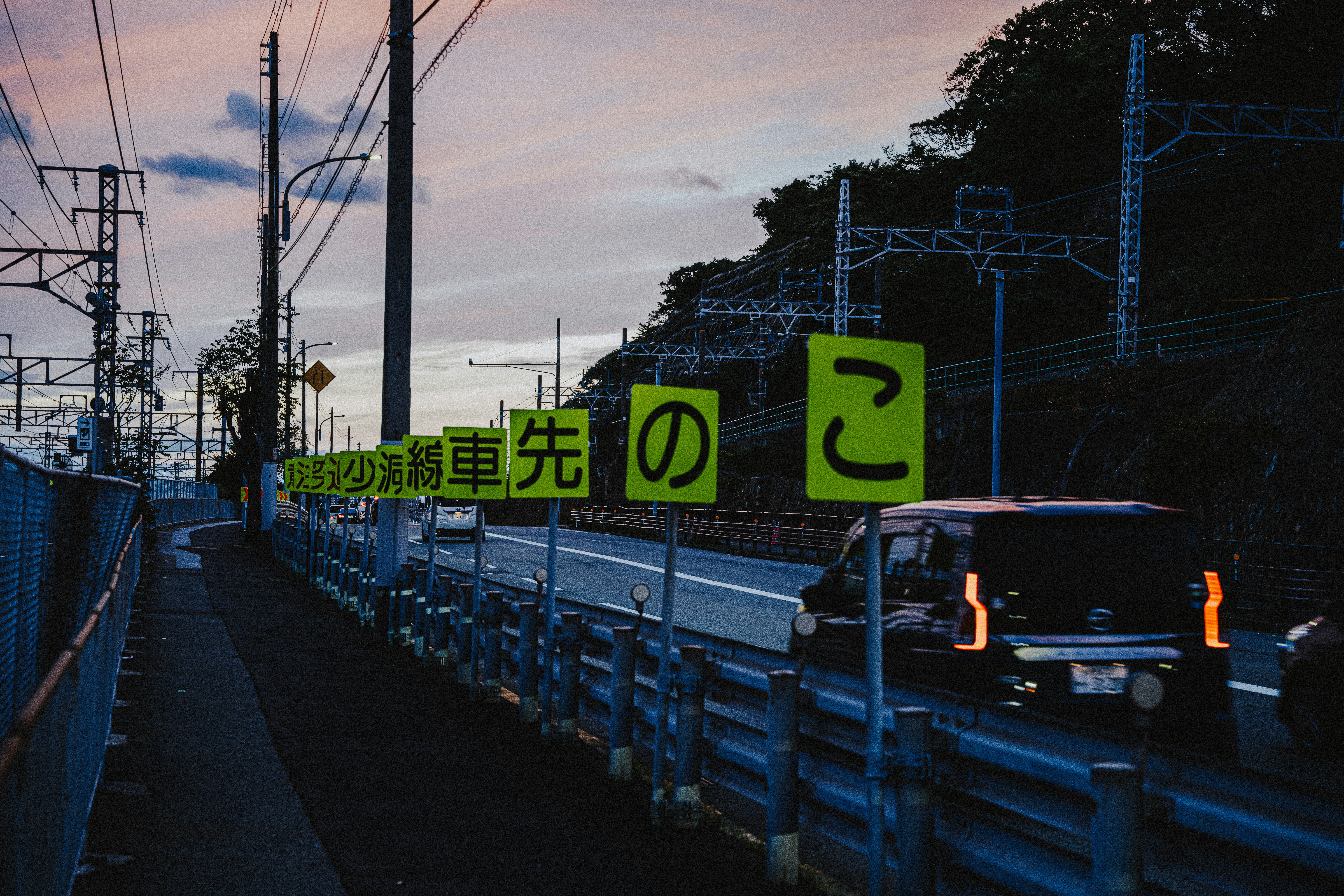 Nighttime Railside Neon: Signboards Illuminate the Highway