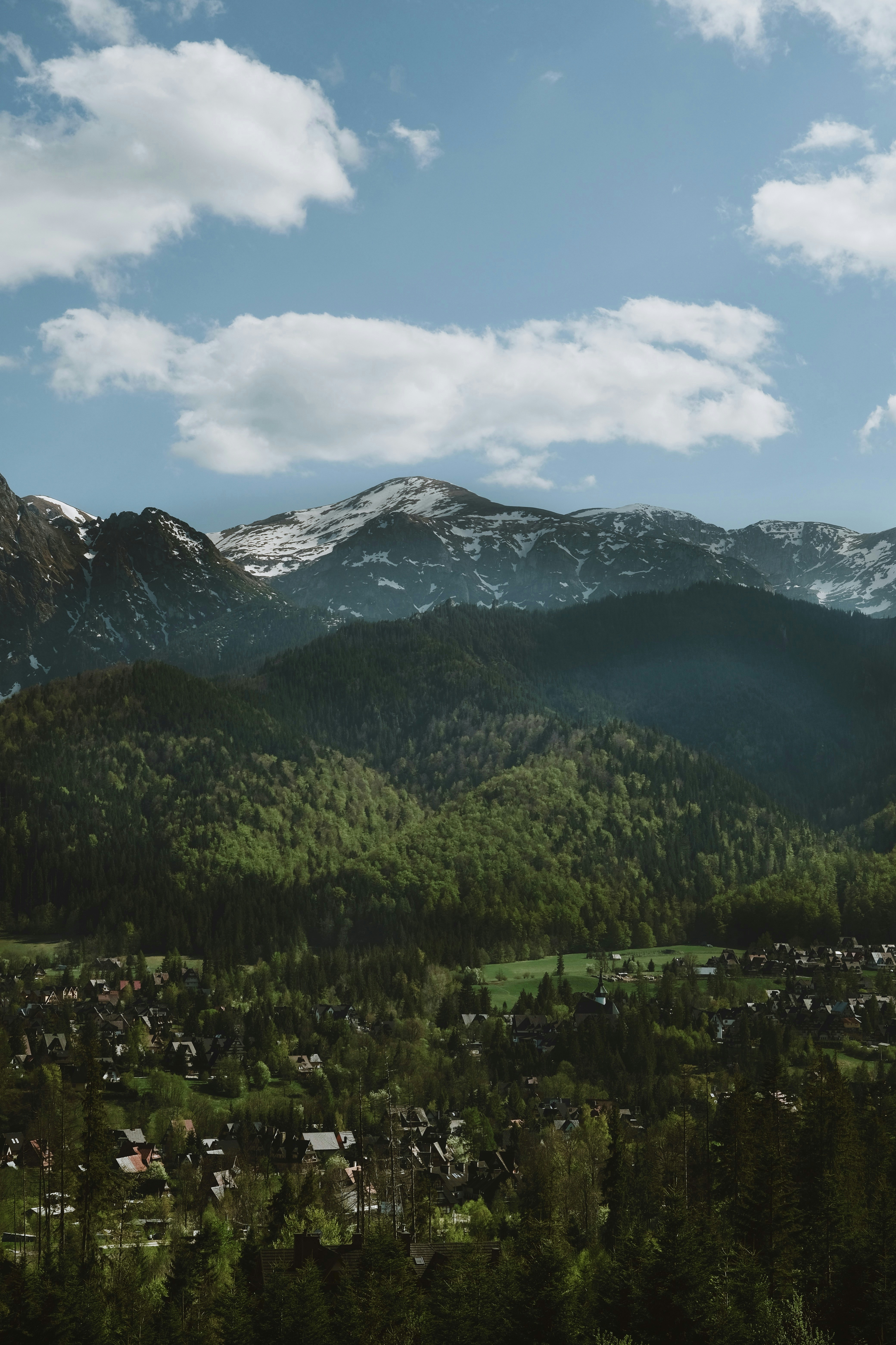 Snow-dusted peaks over a verdant valley village