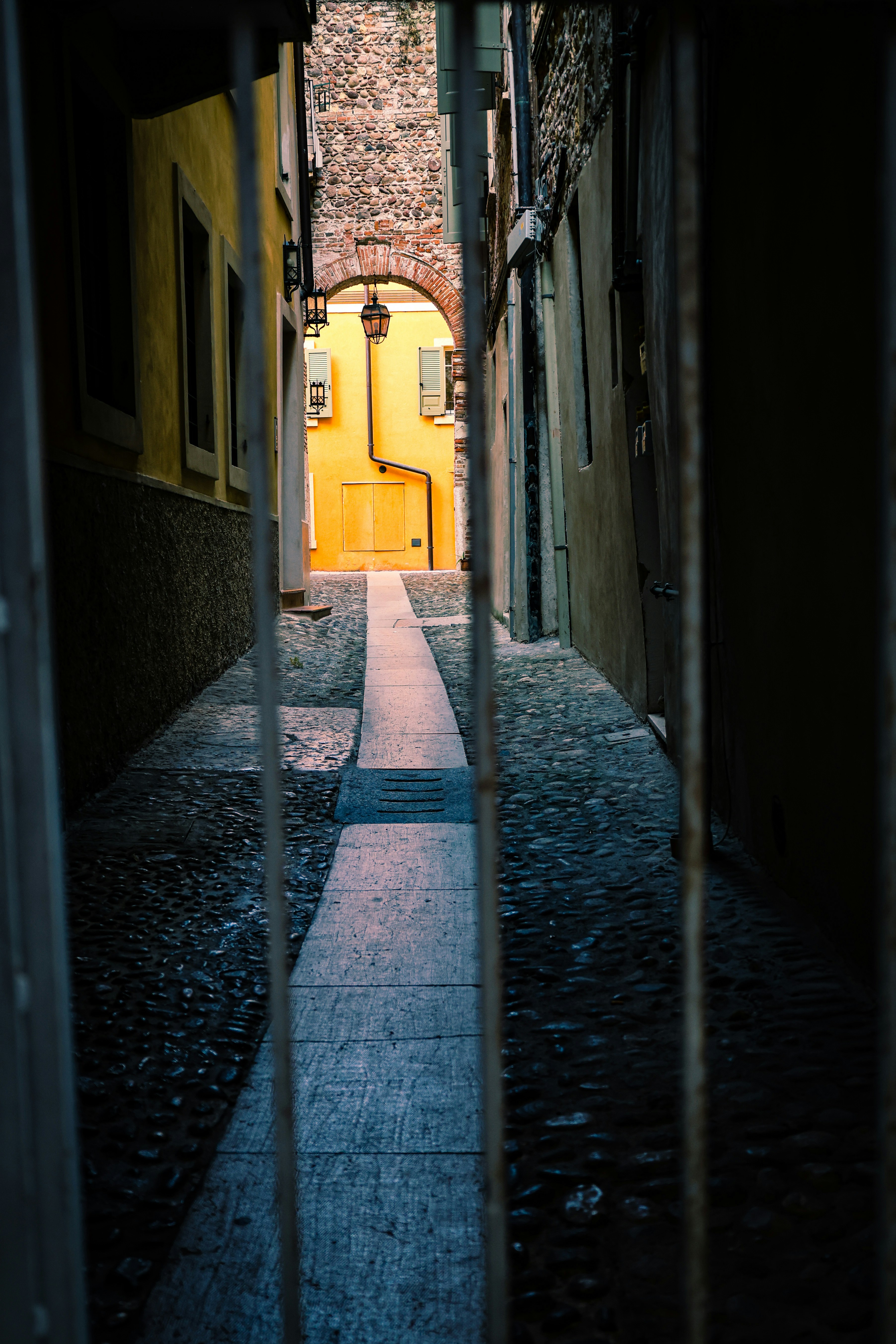 Sunlit Archway at the End of a Cobblestone Alley