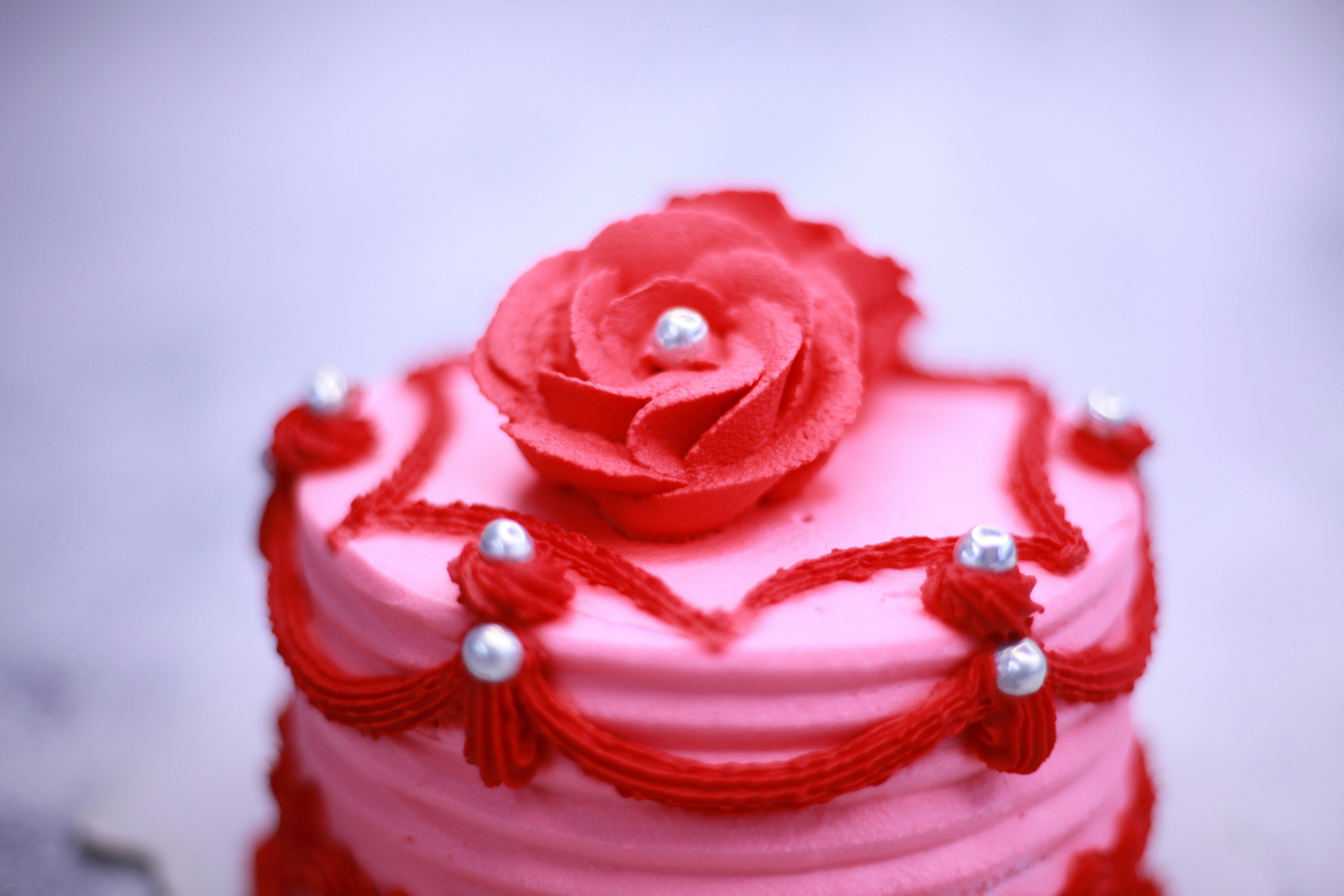 Sweet Crest: A Red Rose Tiered Cake With Pearl Accents