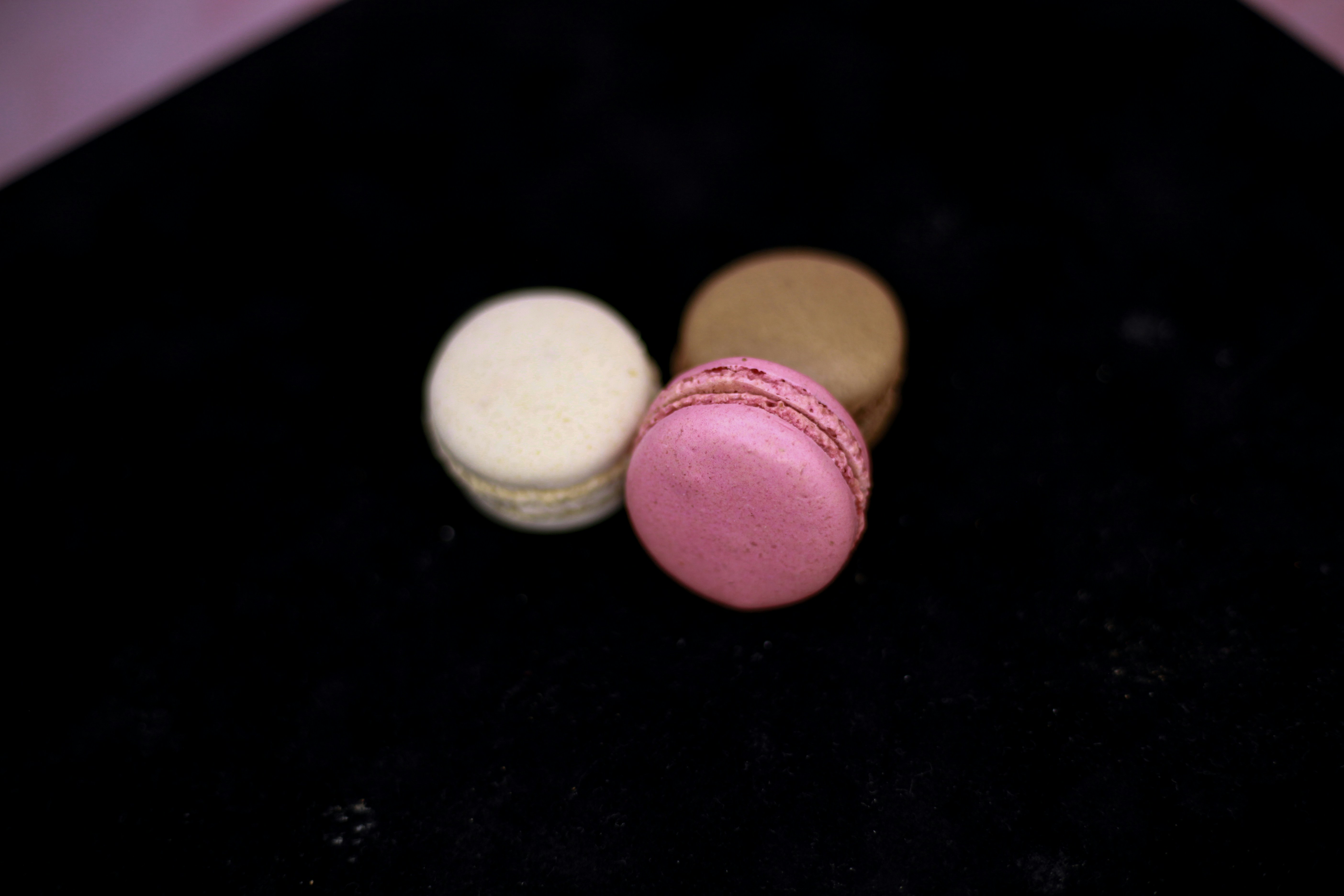 Pink Macaron Lead: A Trio of Delicate Pastries Rest on Velvet Night