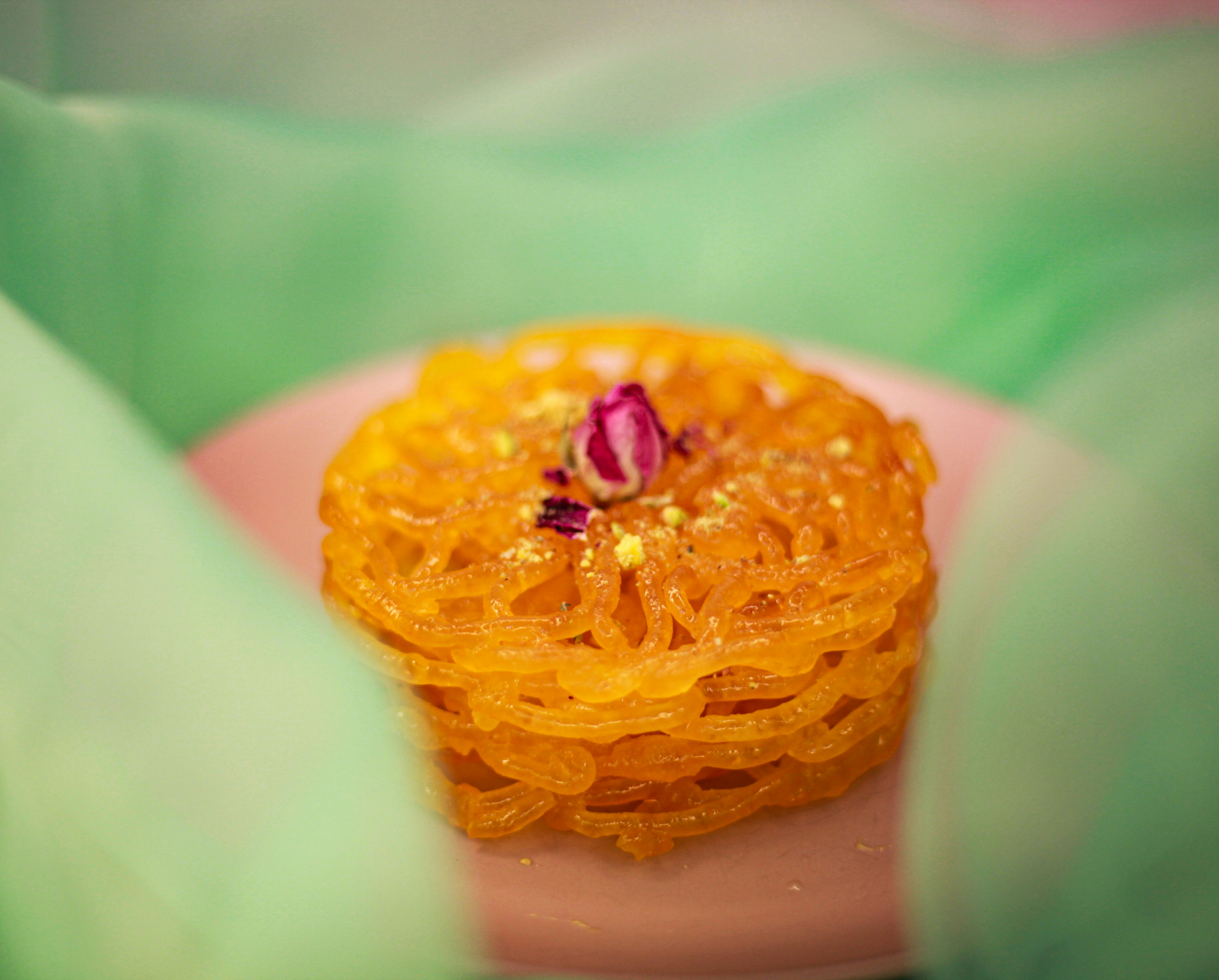 Golden lattice of sweetness: an amber nest crowned with a rosebud