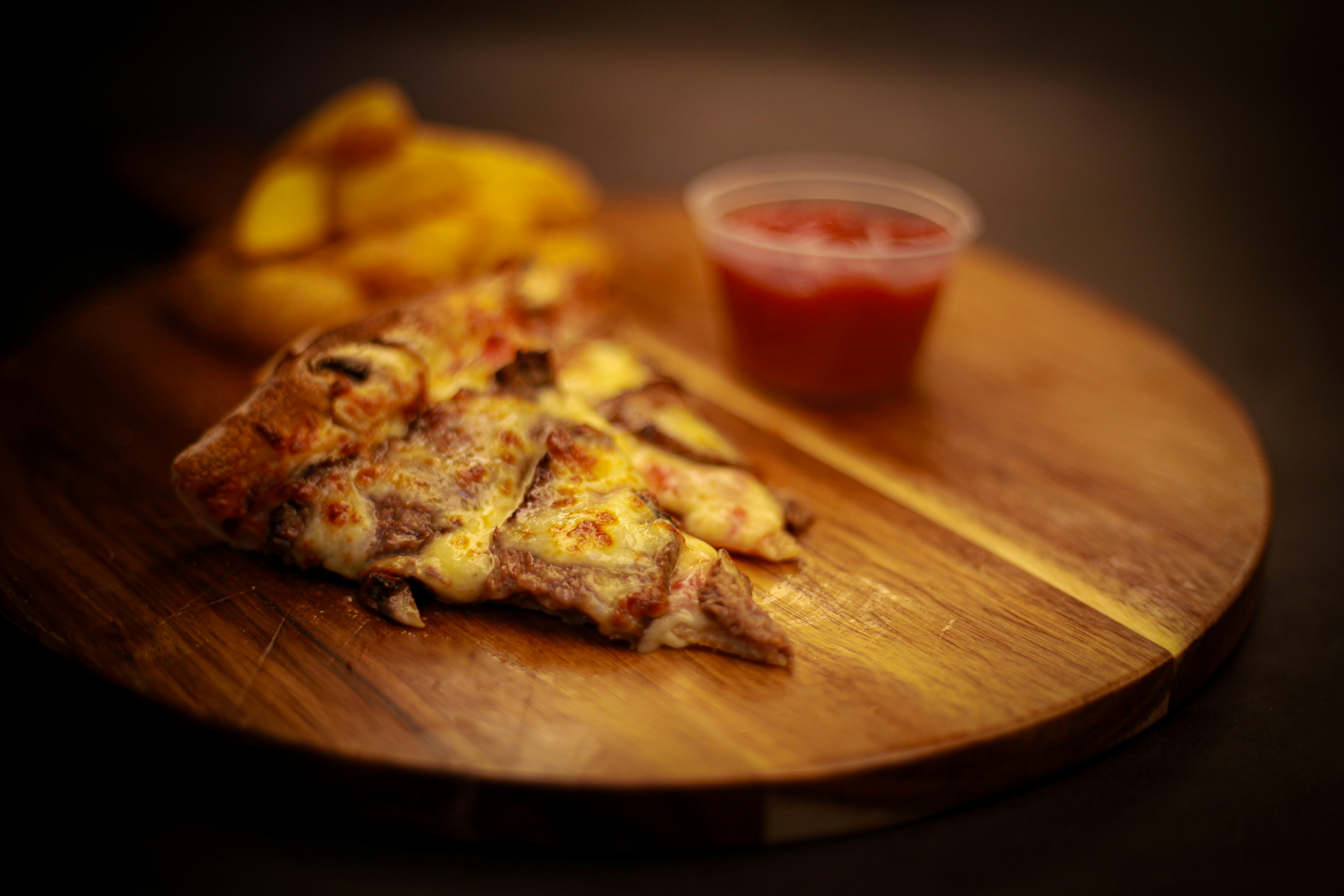 Slice in the Spotlight: Cheese-Studded Pizza on a Wooden Board