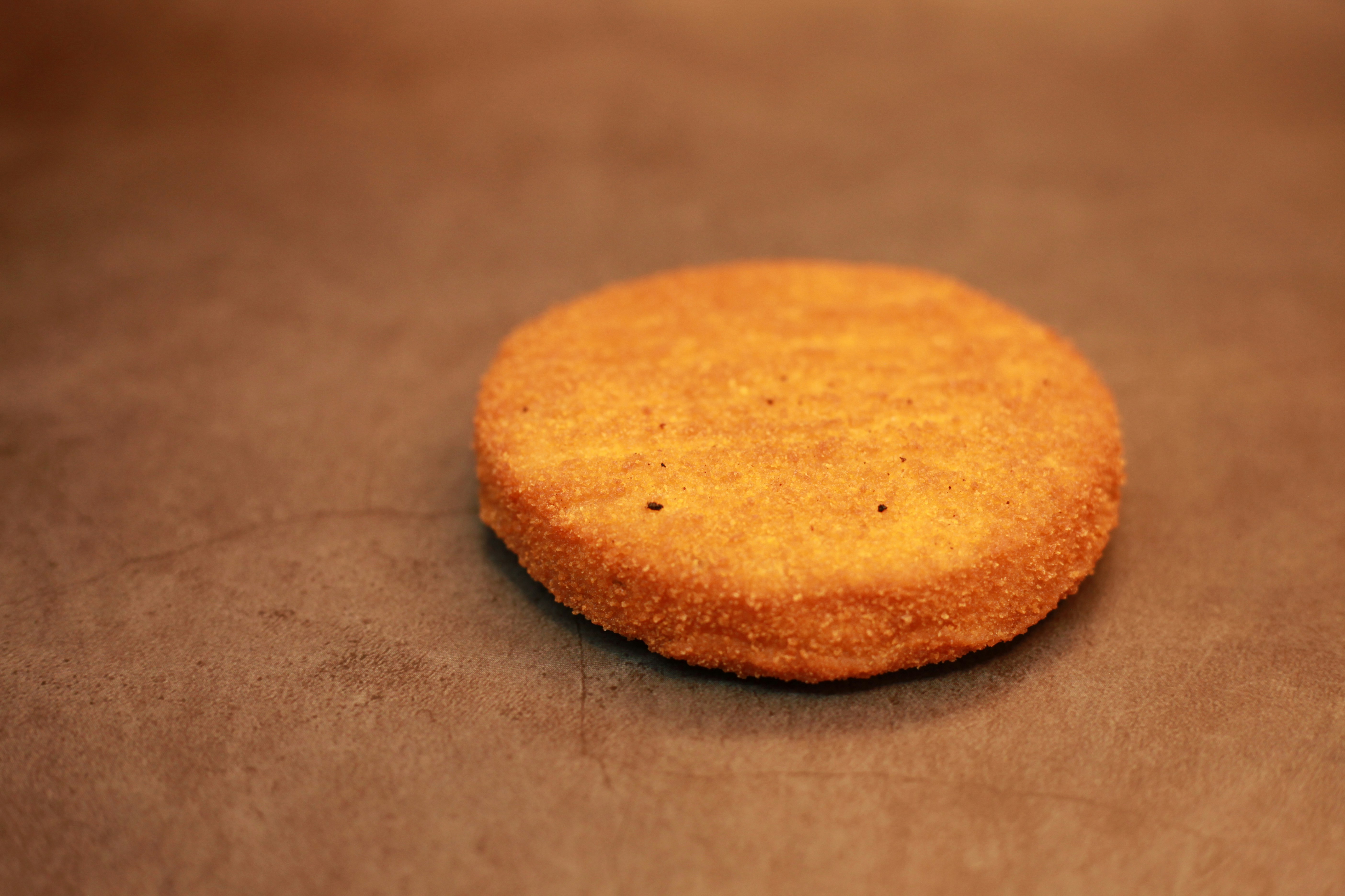Single Crisp Cookie Resting on a Subtle Stone Surface