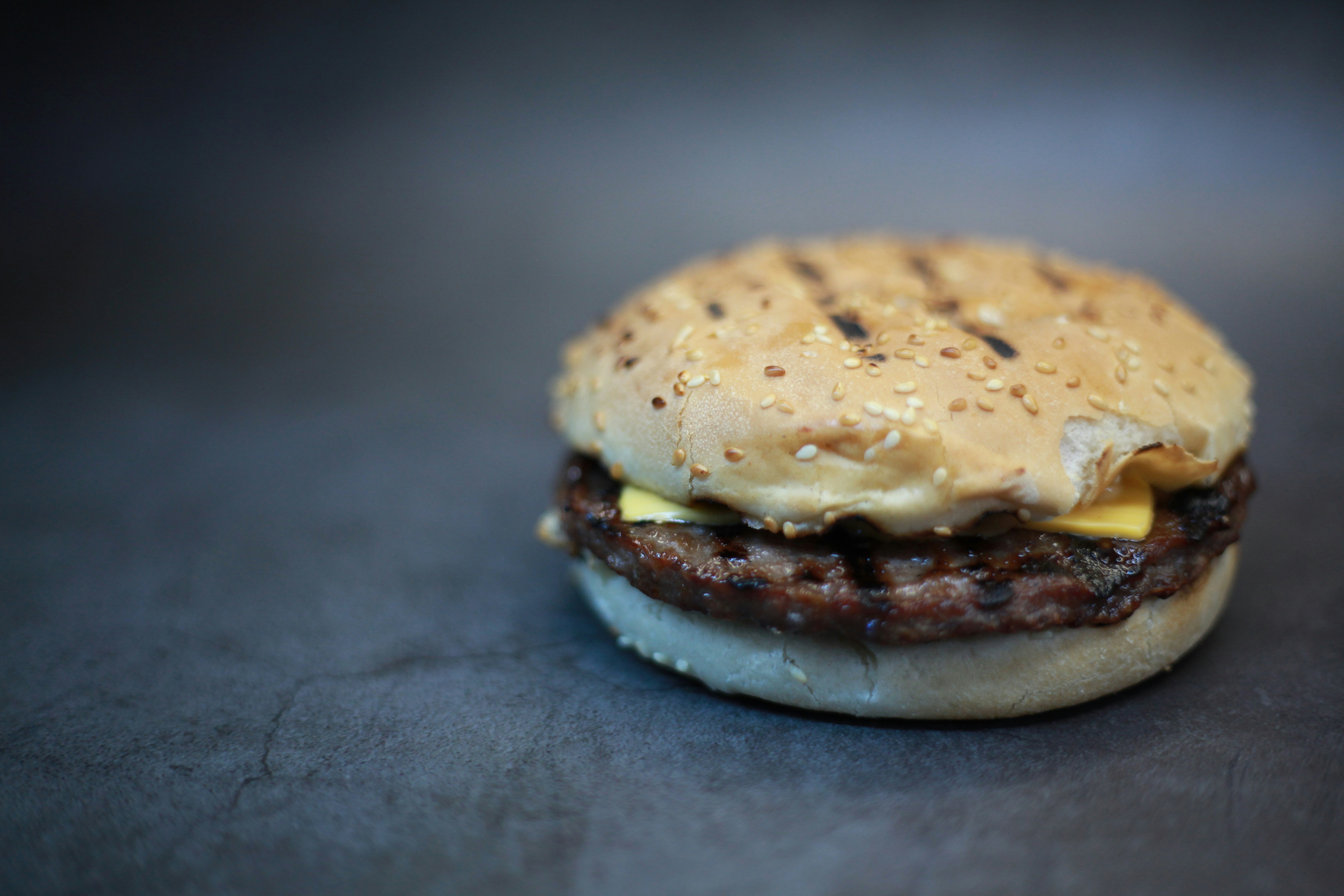 Sesame-Studded Burger on a Quiet, Concrete Stage