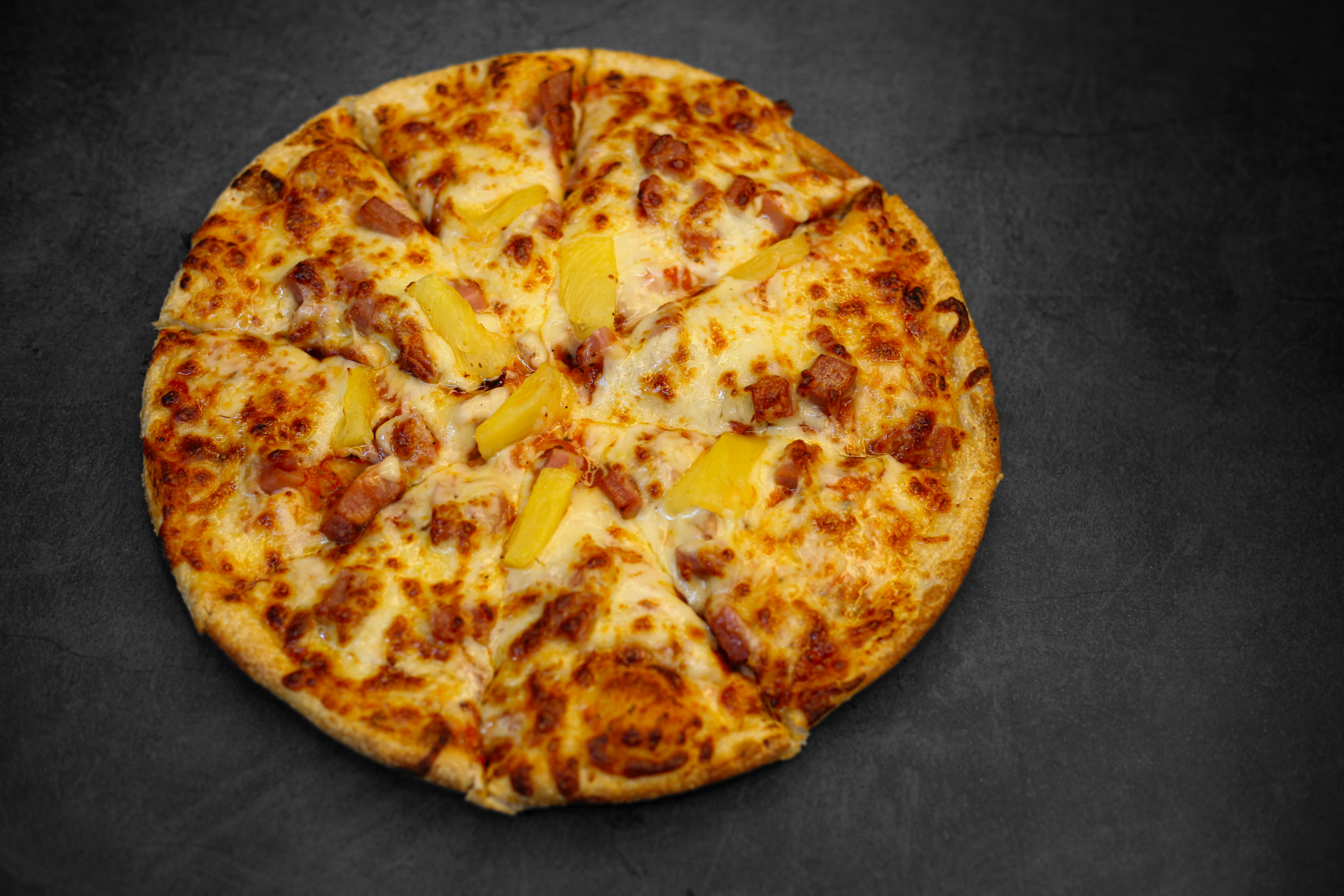 Golden Ringed Circle: Pineapple-Pepperoni Pizza on A Slate stage