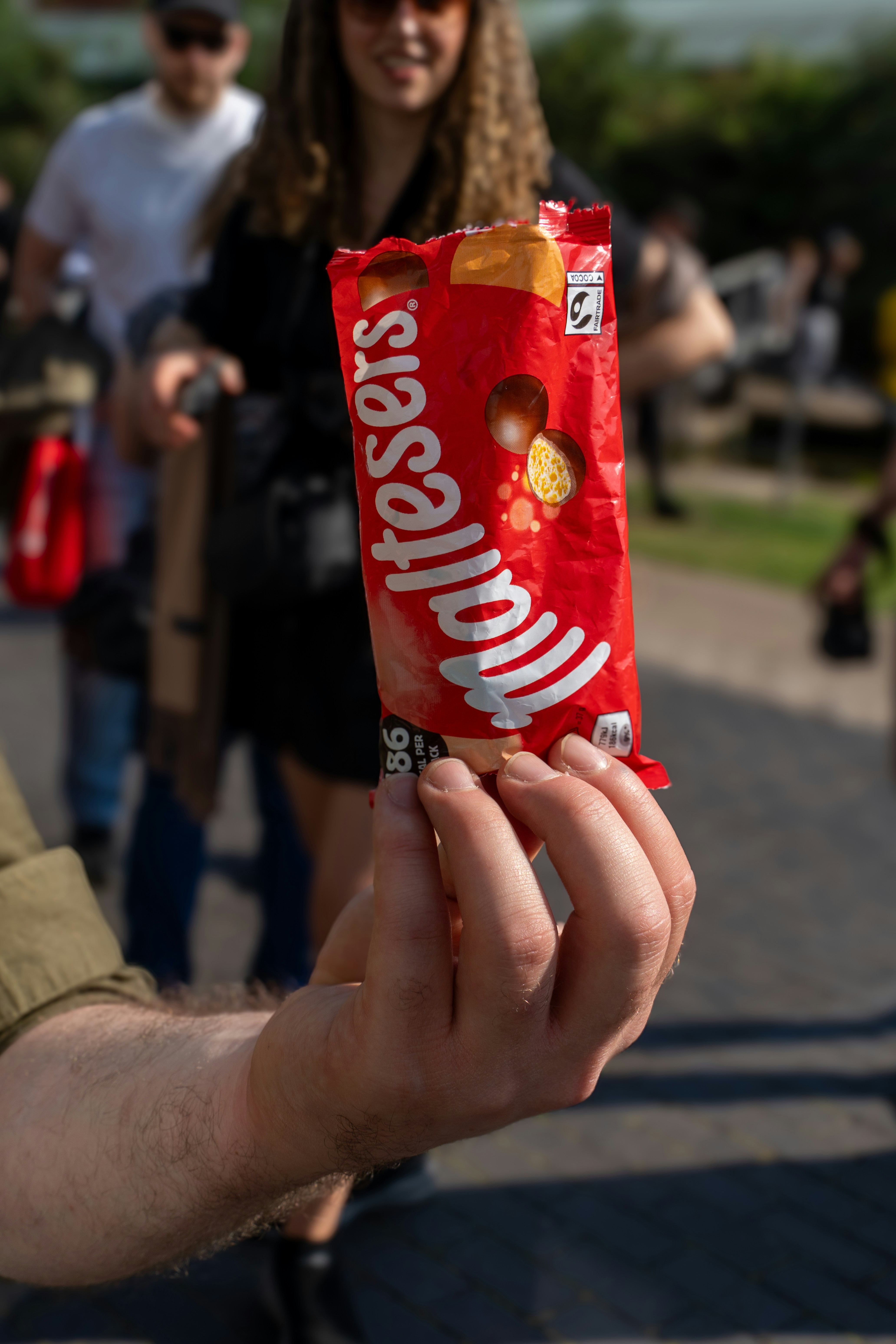 Crinkled Prerogative: A Handful of Snack Held Forward