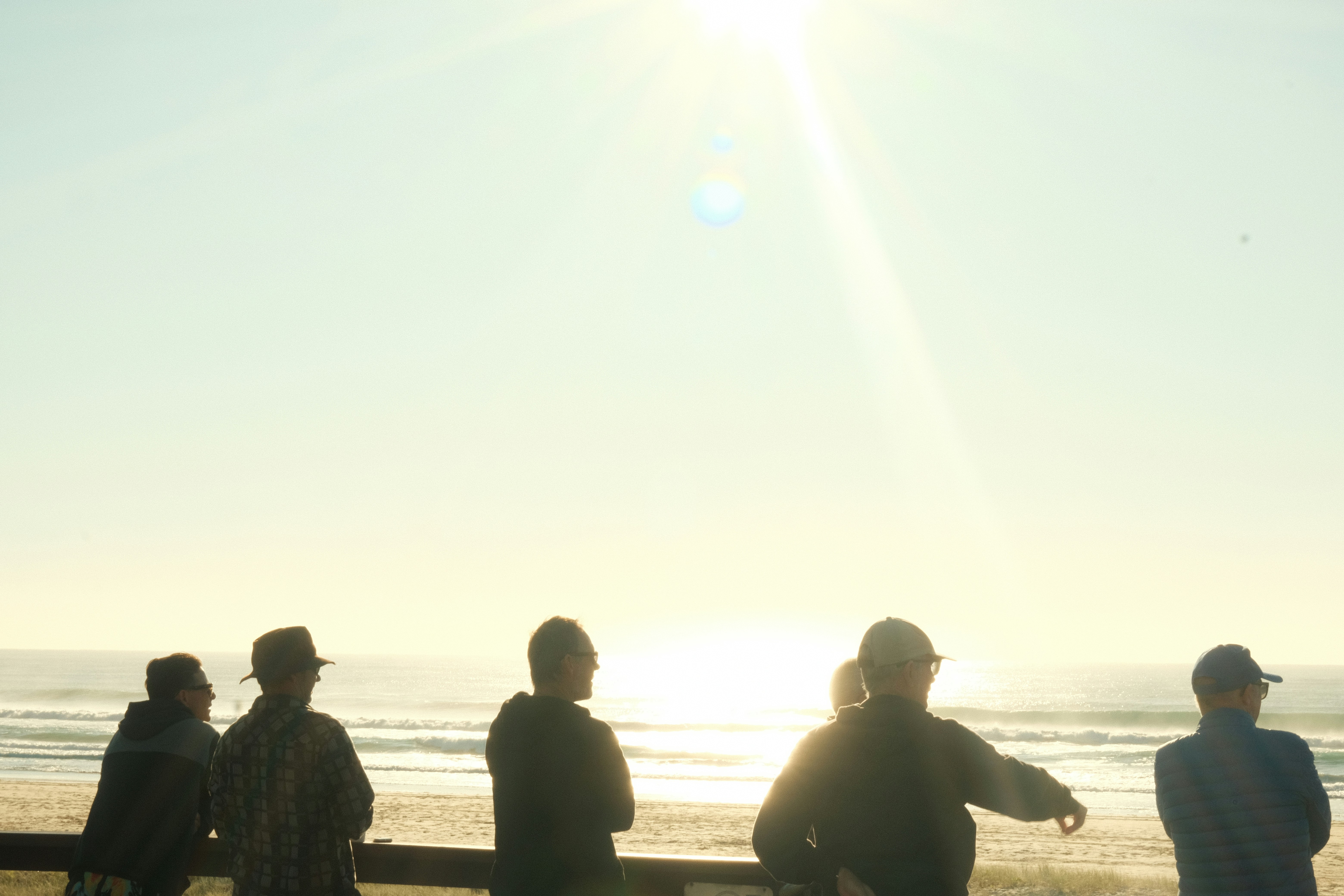 Sunlit Seabreeze: A Small Group Stares Toward the Horizon