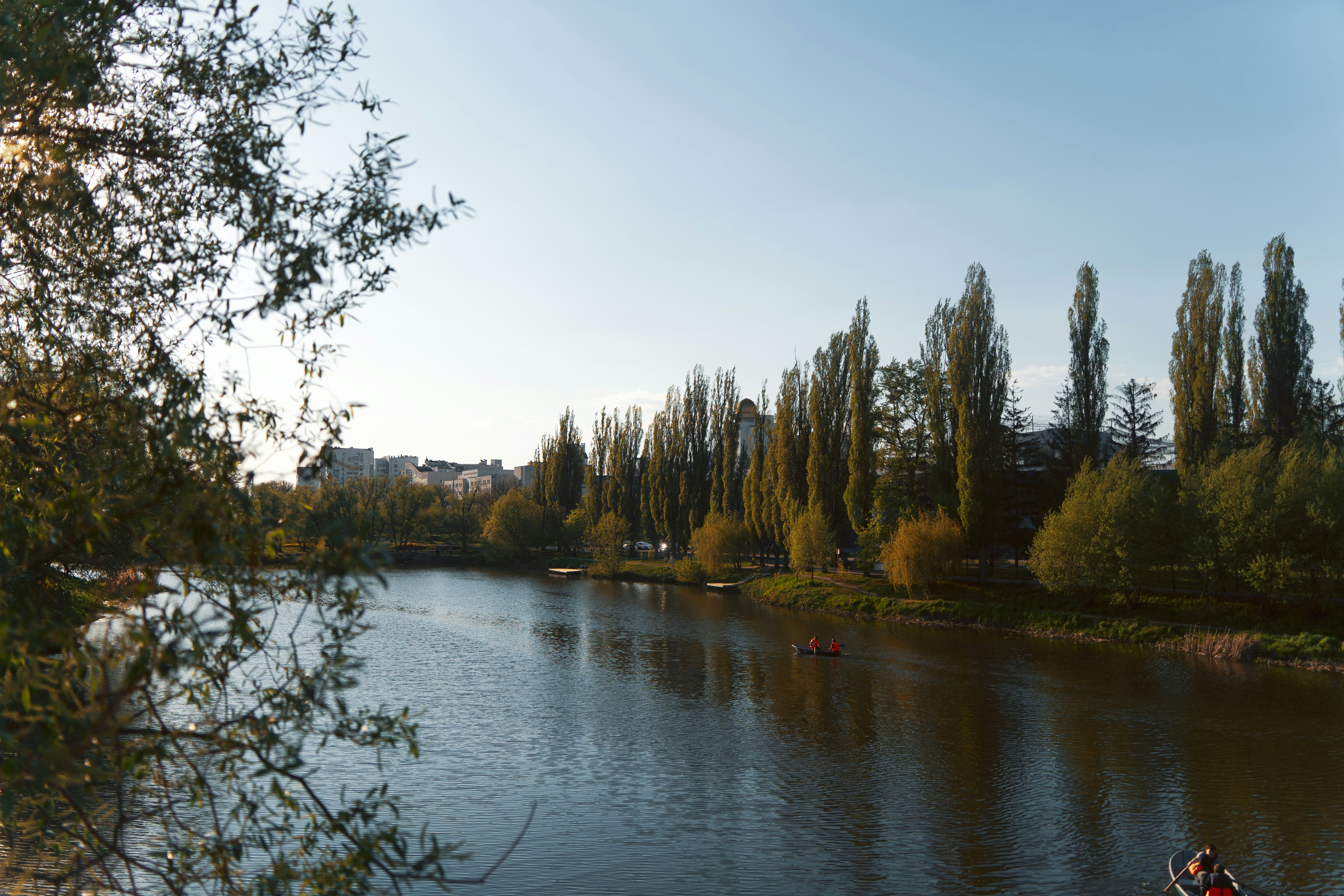 Riverside Symphony: Trees, Light, and Quiet Boats