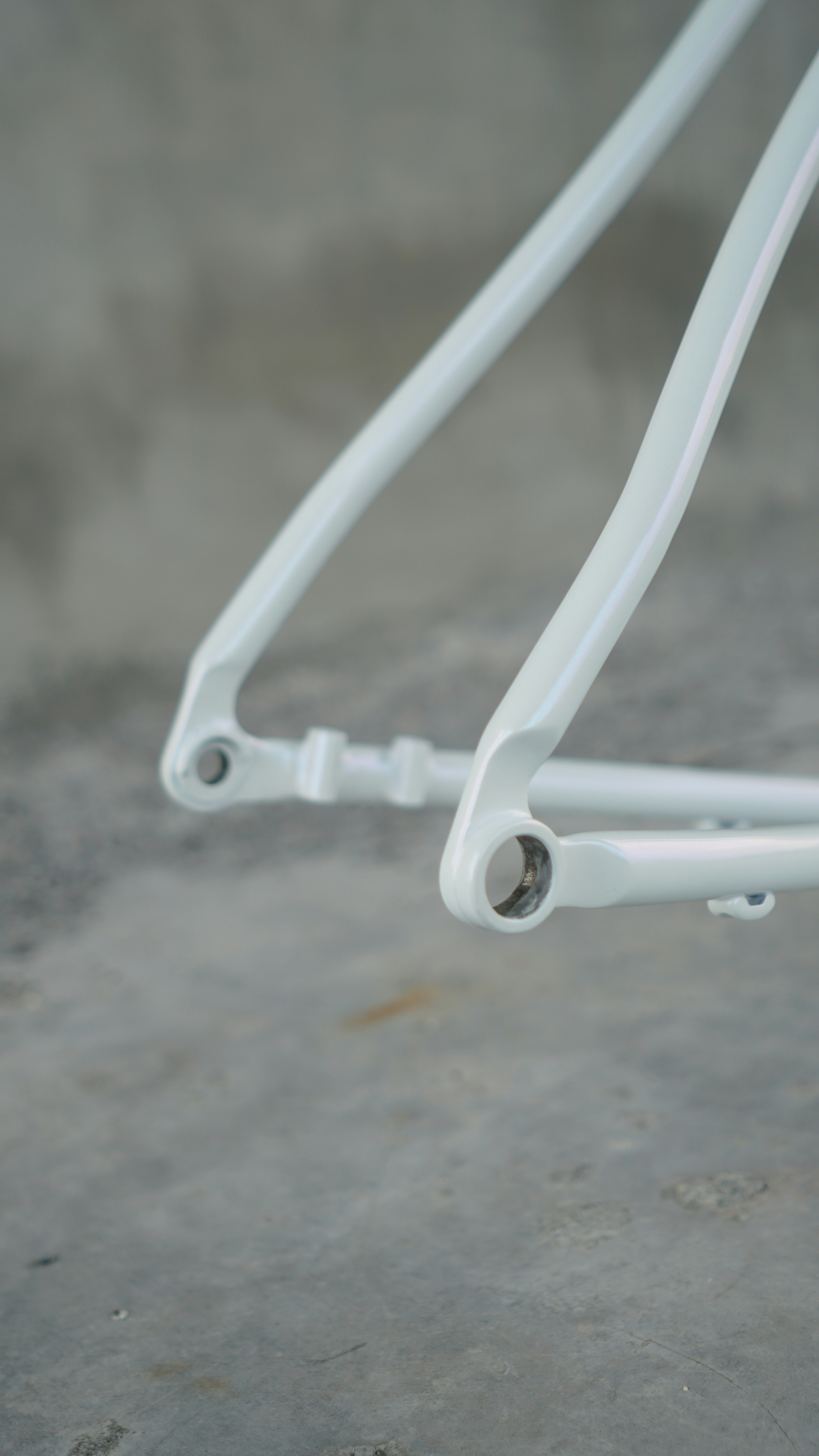 Bare Minimal: White Bicycle Frame Angles on a Concrete Floor