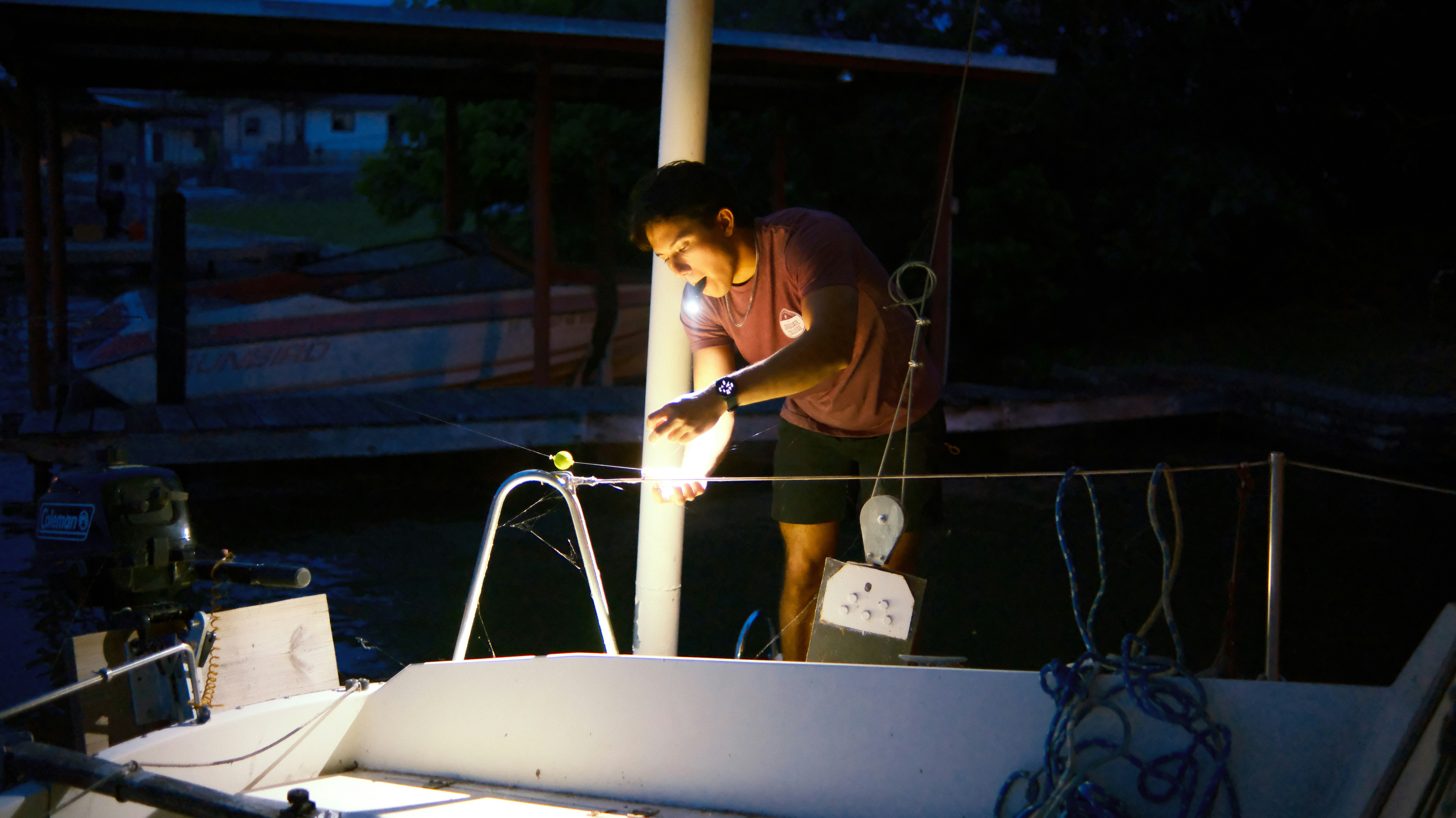 Night Repairs: A Sailor at Work Under Soft Dock Light
