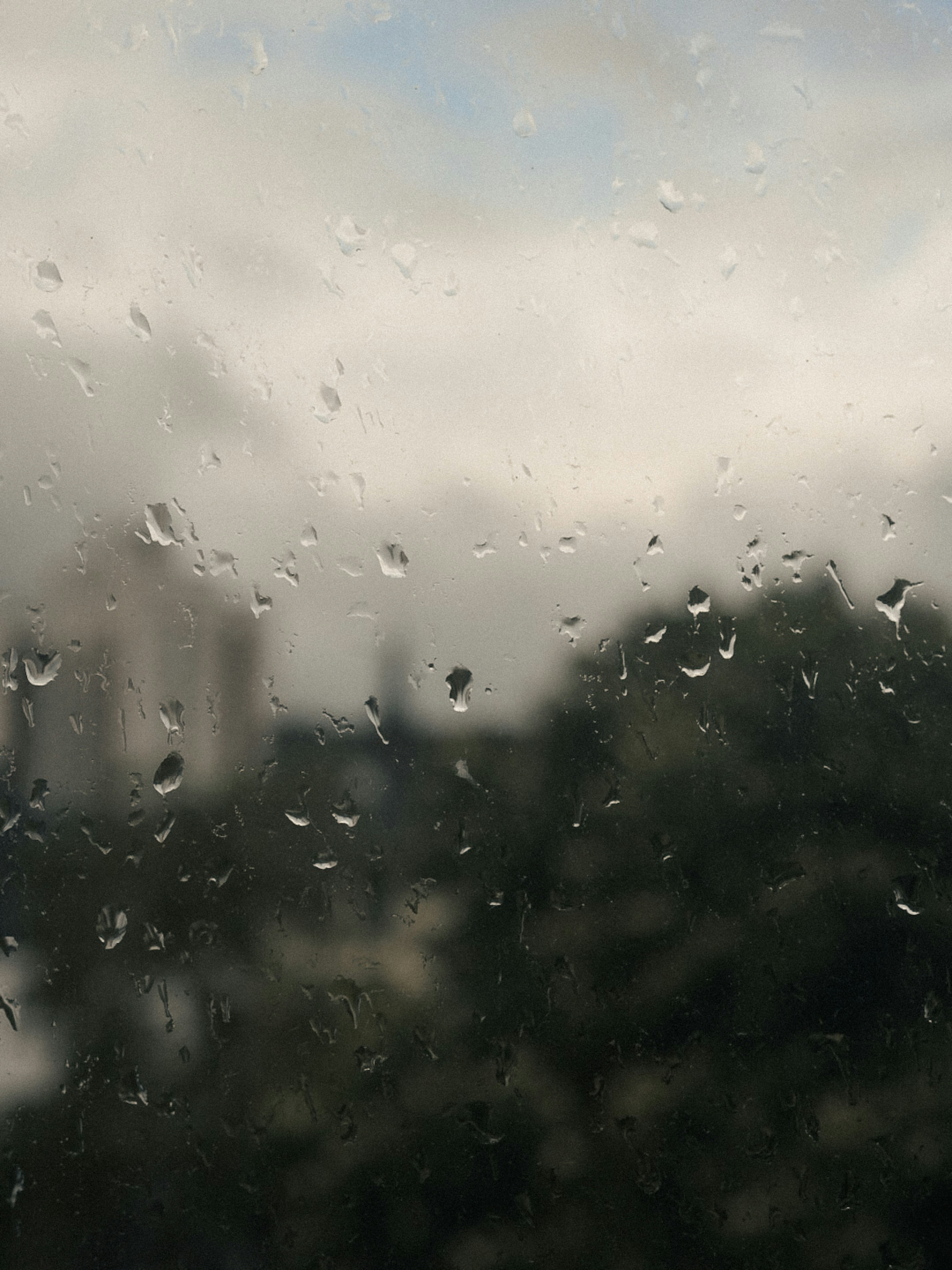 Rain-Streaked Window over a Distant Cityscape