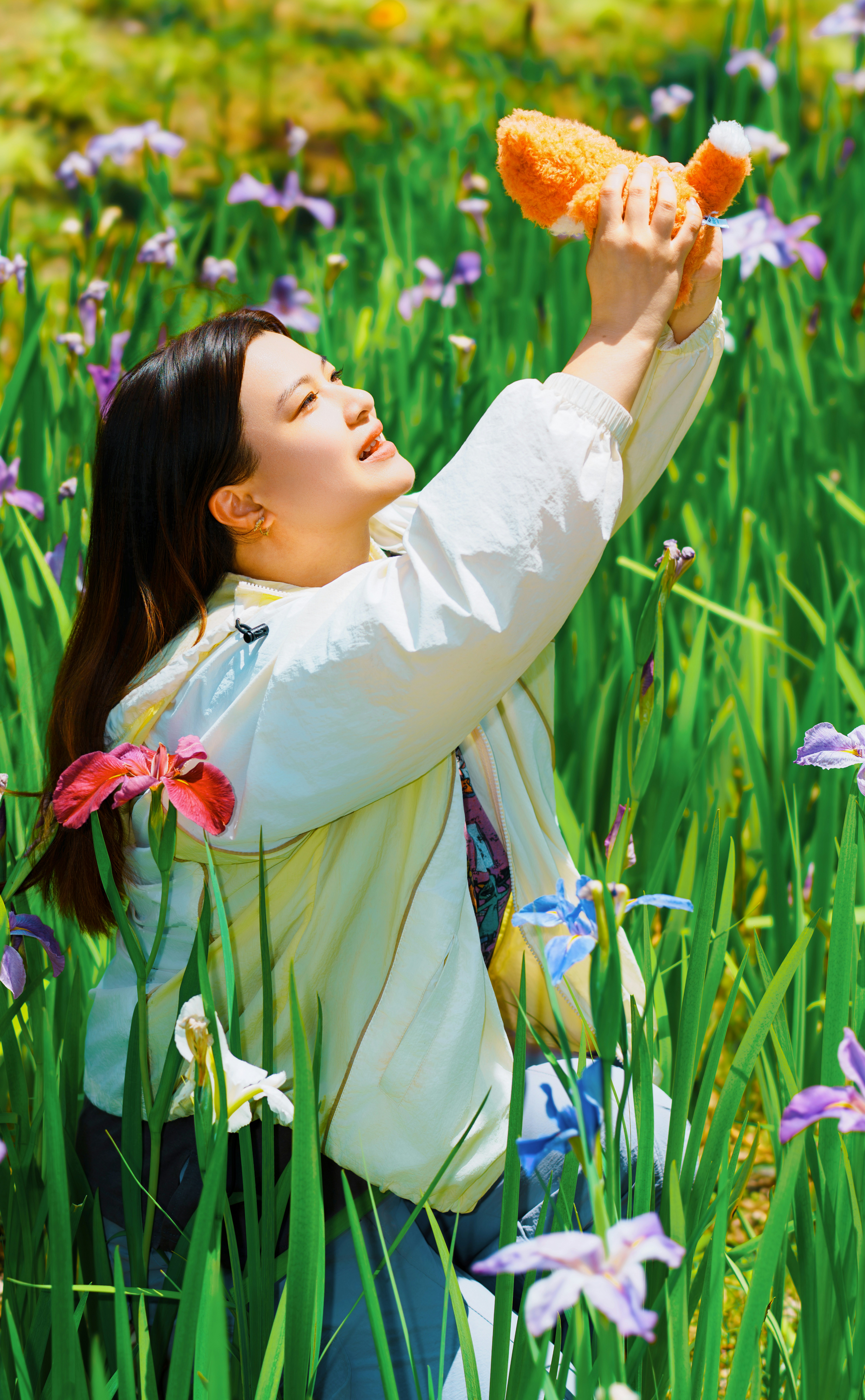 Joyful Lift: A Woman Reaches for a Plush Snack Amid Iris Fields
