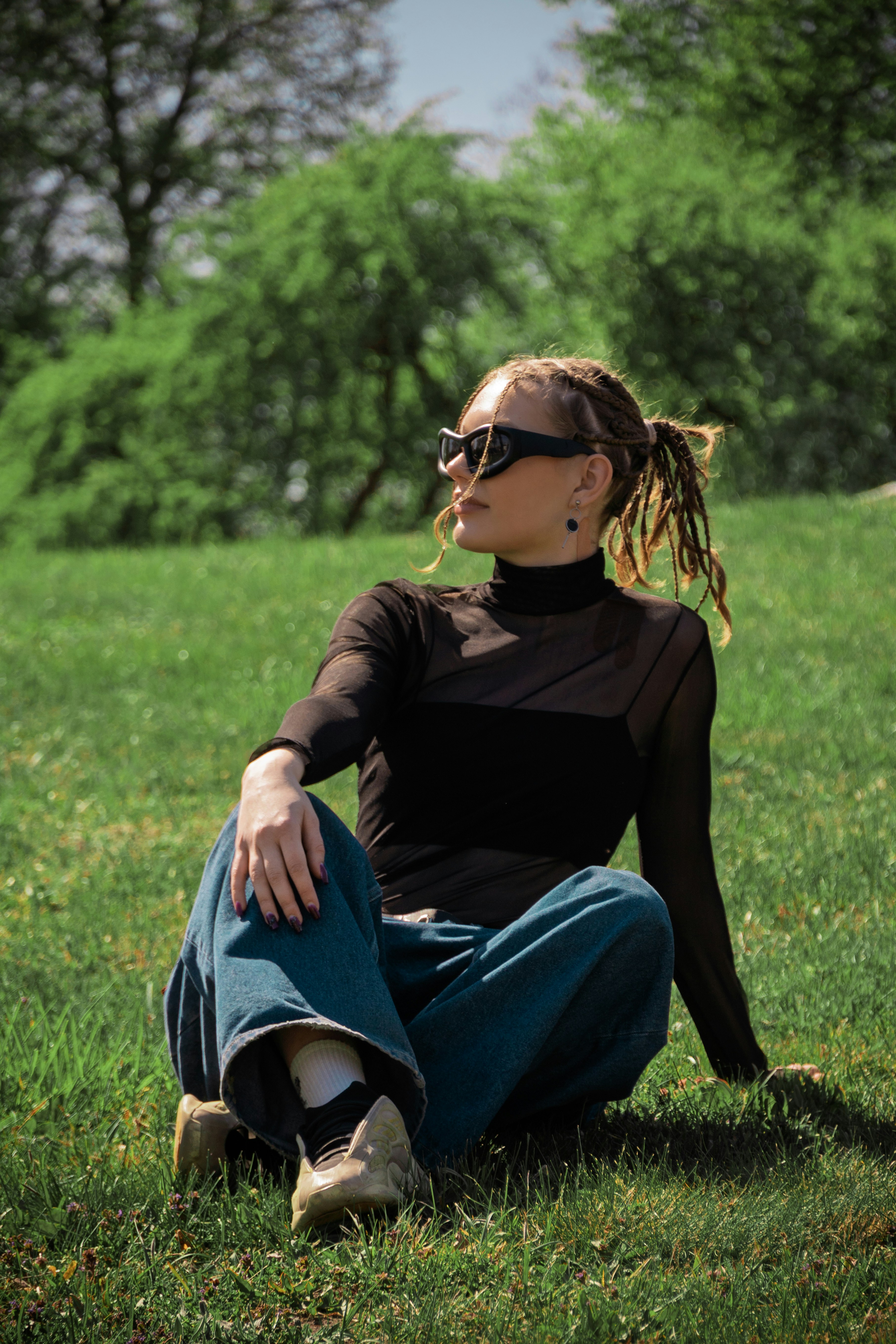Sunlit Quiet: A Woman in Glasses Reclines on a Green Crest