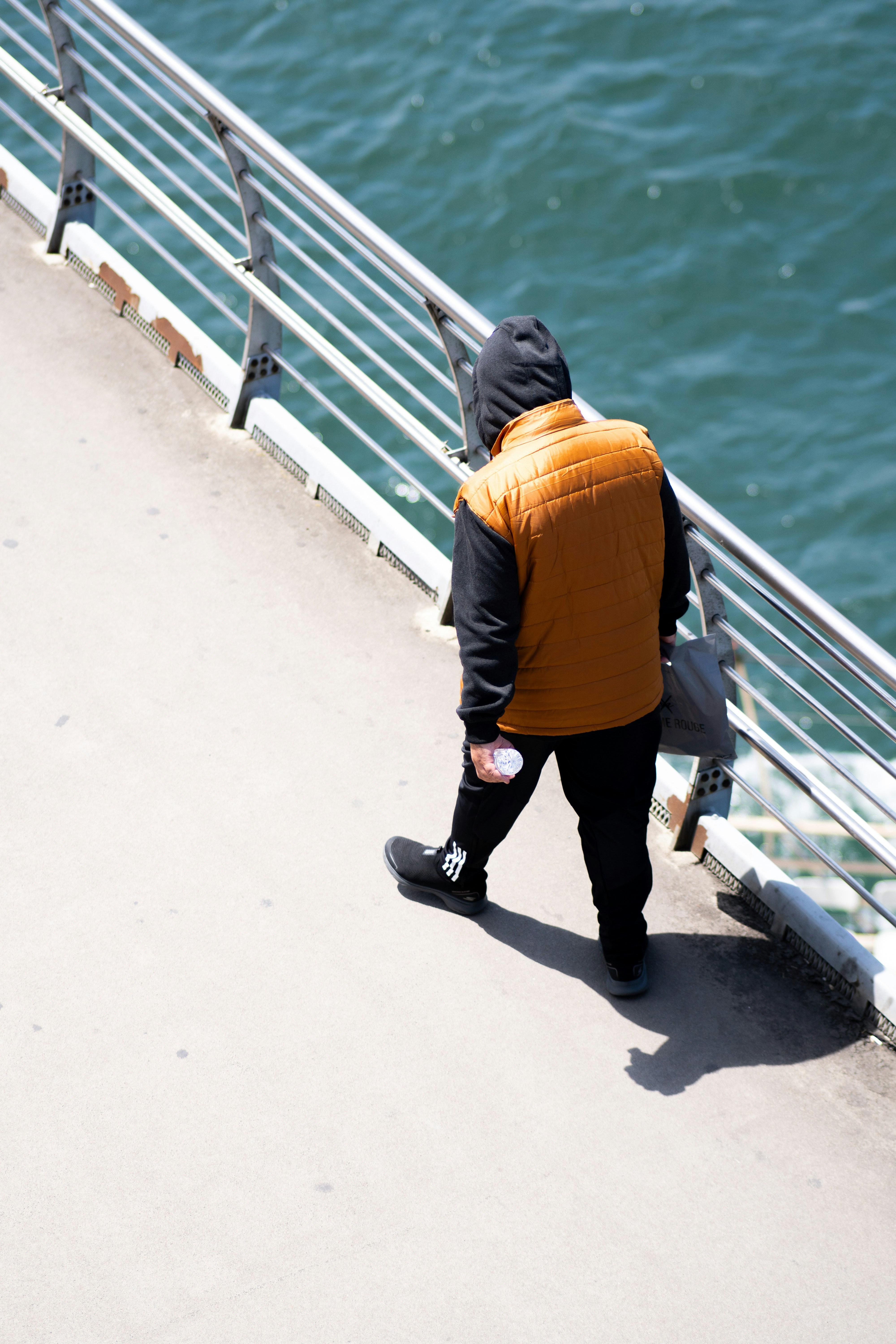 On the Edge: A Hoodie-Clad Figure Stepping Toward the Water