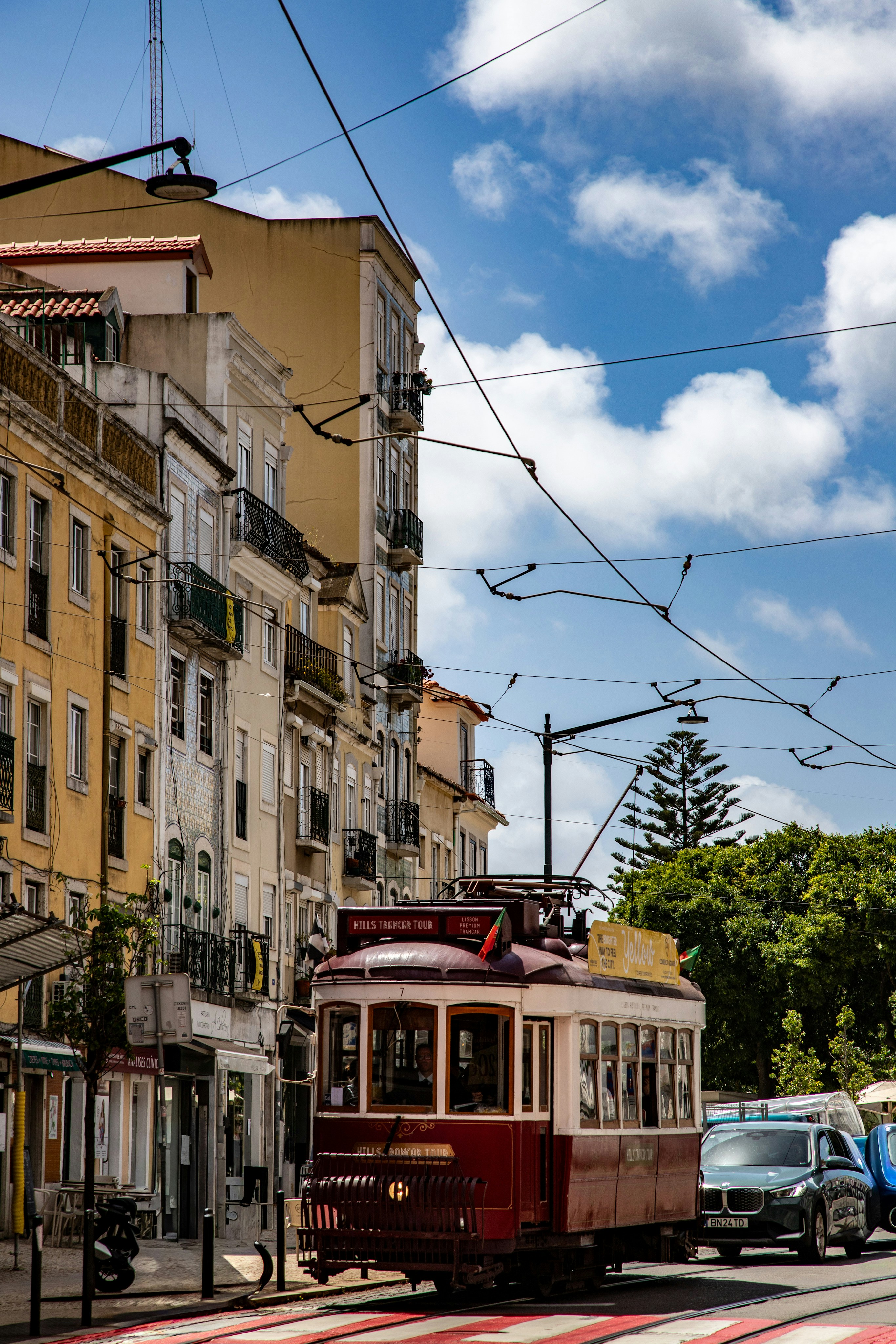 Historic tram negotiating a sunlit Lisbon-style alley