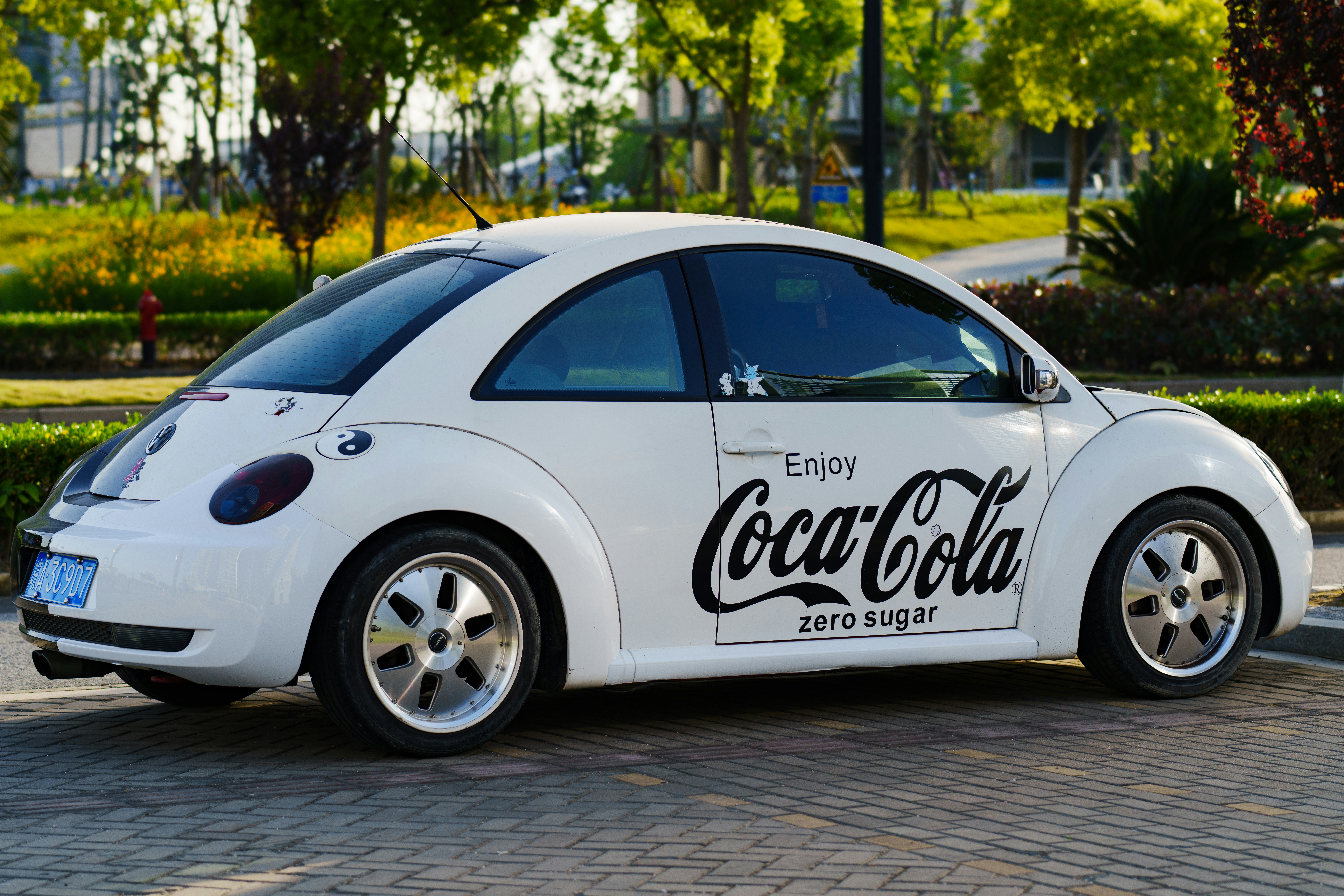 Coca-Cola Cruiser: Classic White Beetle Resting in a Park