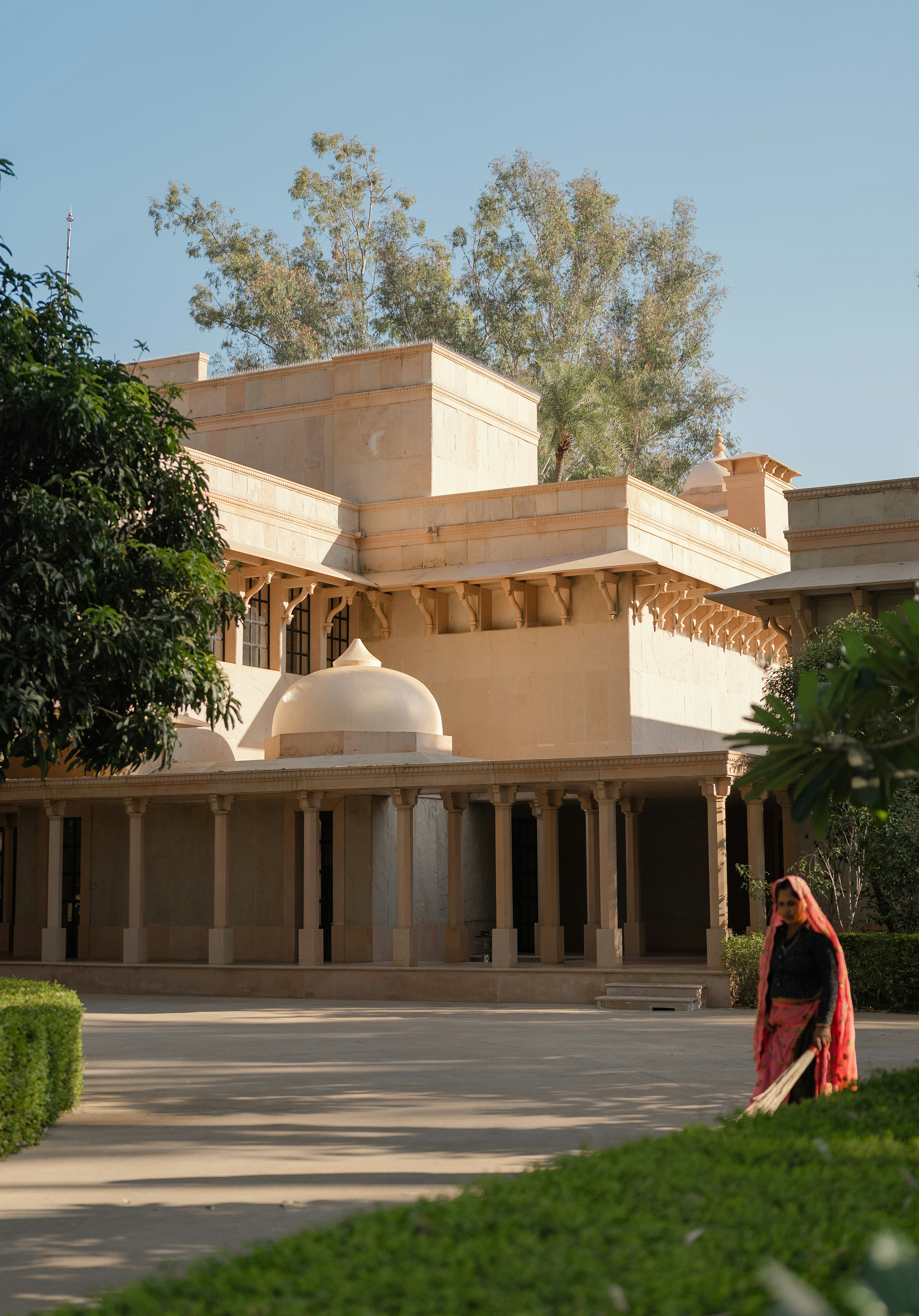 Heritage Courtyard: Woman in pink Sari By the Moorish Facade