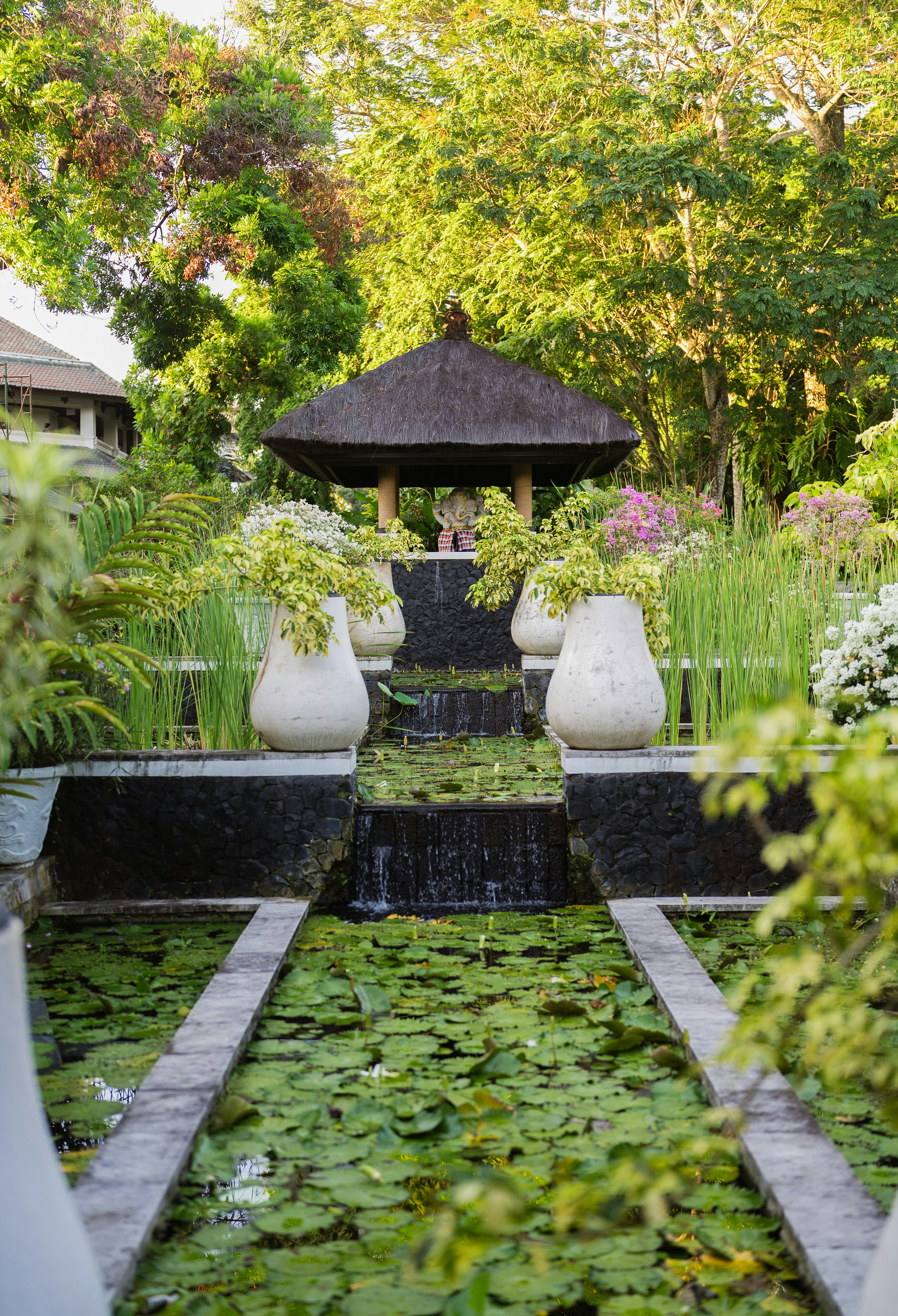 Tranquil Waterways and Stone Urns in a Balinese-inspired Garden