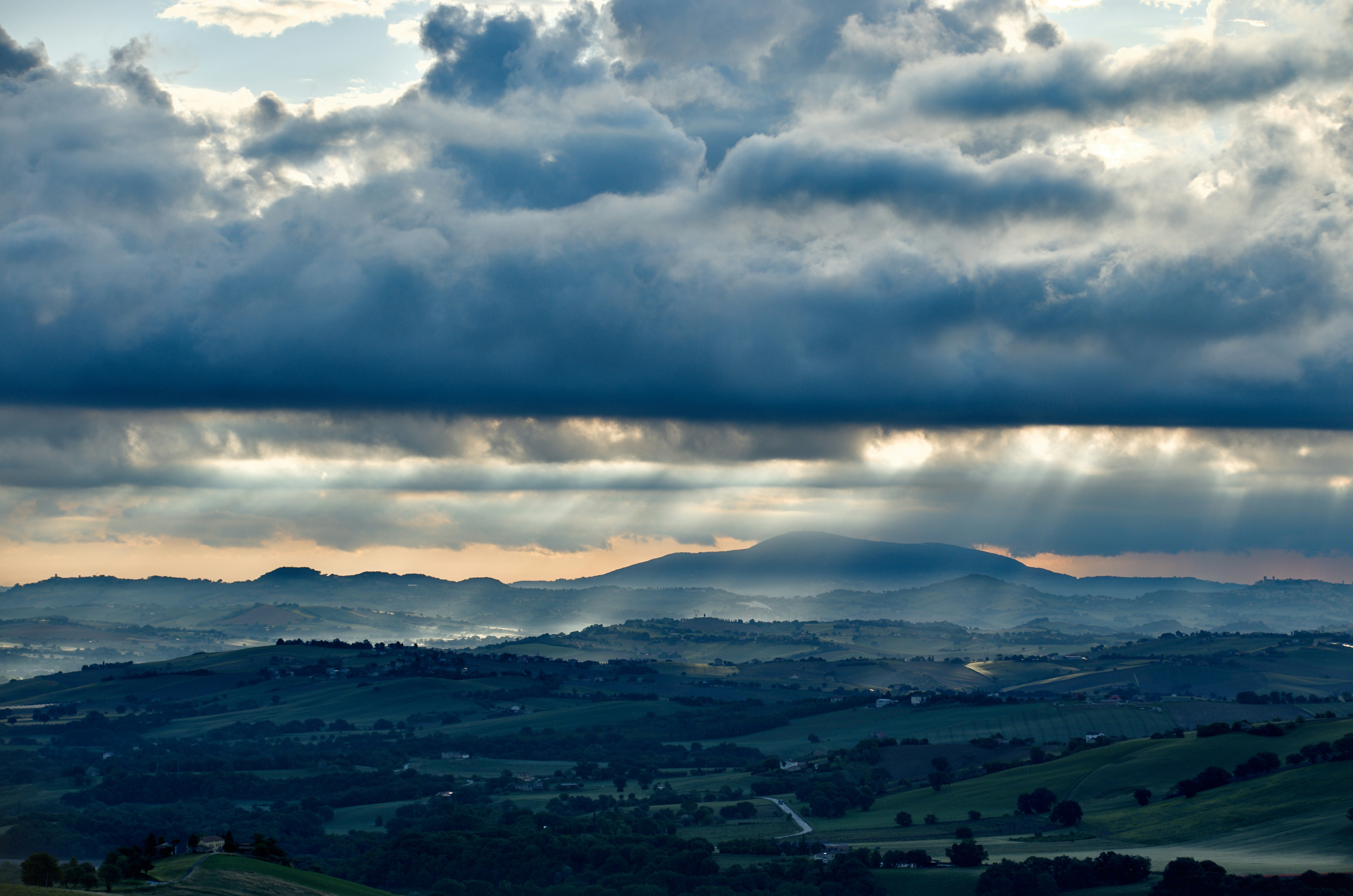 Rolling Hills at Dusk: A Quiet Valley Under Layered Clouds