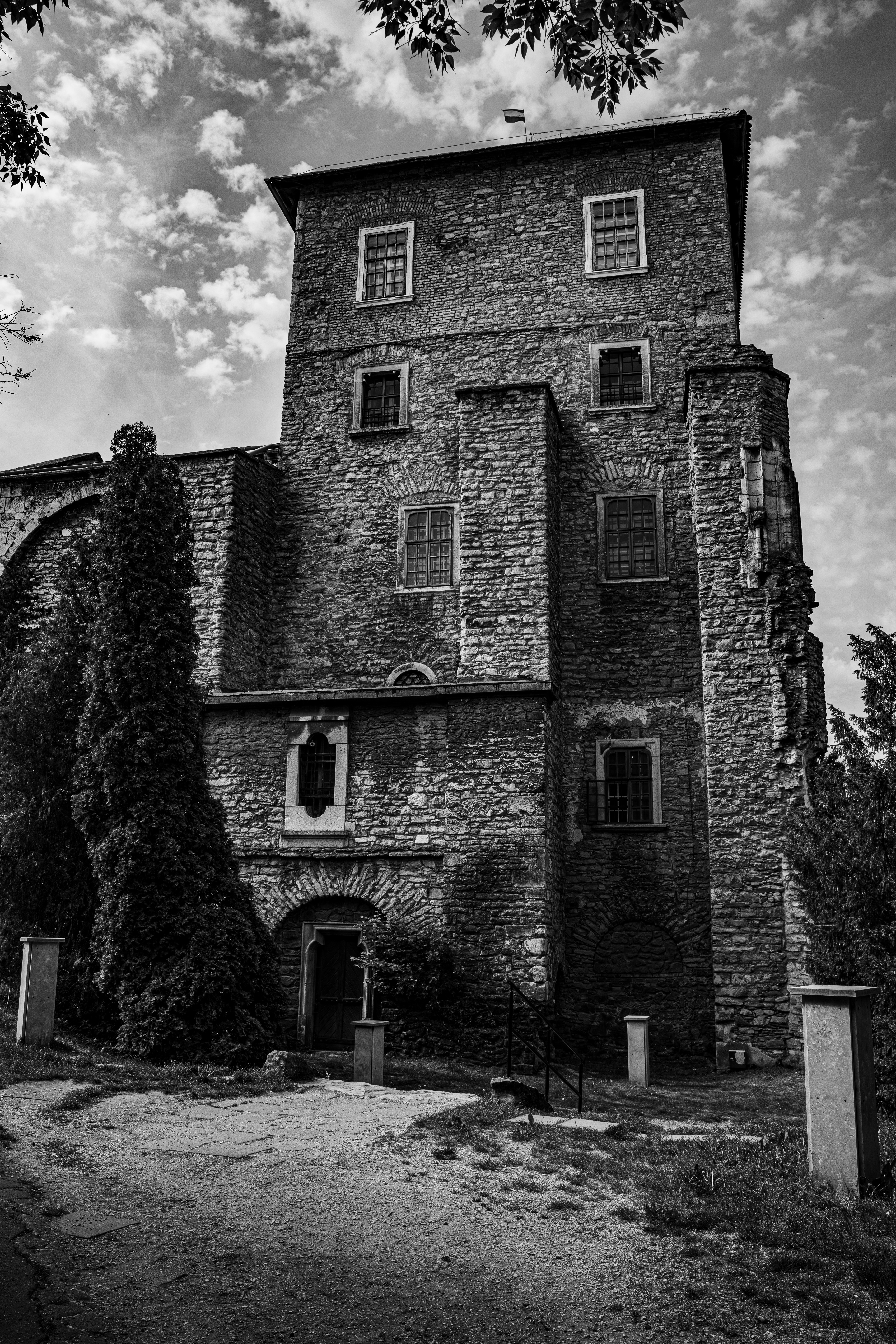 Weathered Keep: A Harsh Gable of Stone Under a Sky of Quiet Clouds