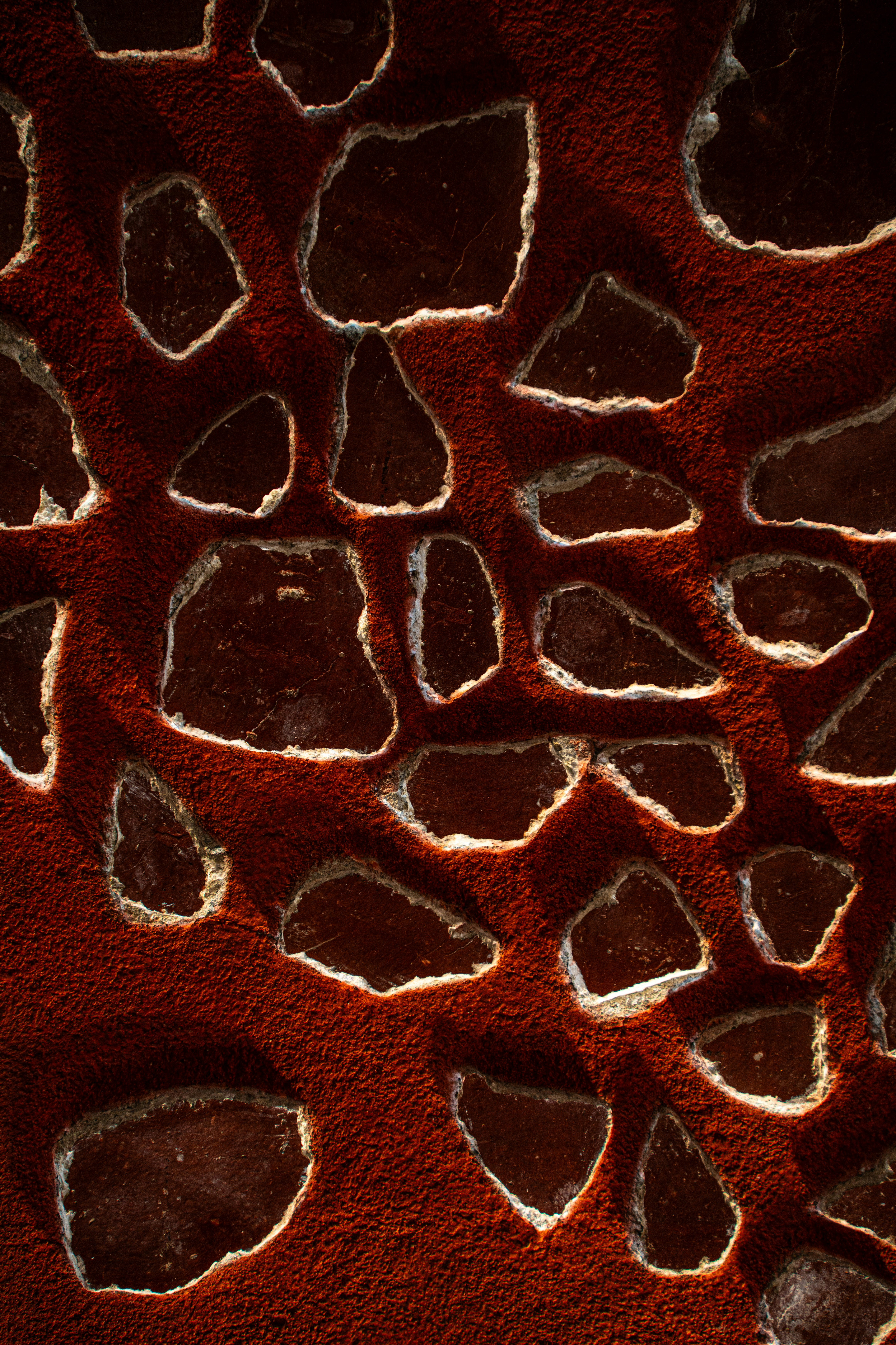 Red Stone Mosaic: Irregular Dark Stones in Rusty Ground