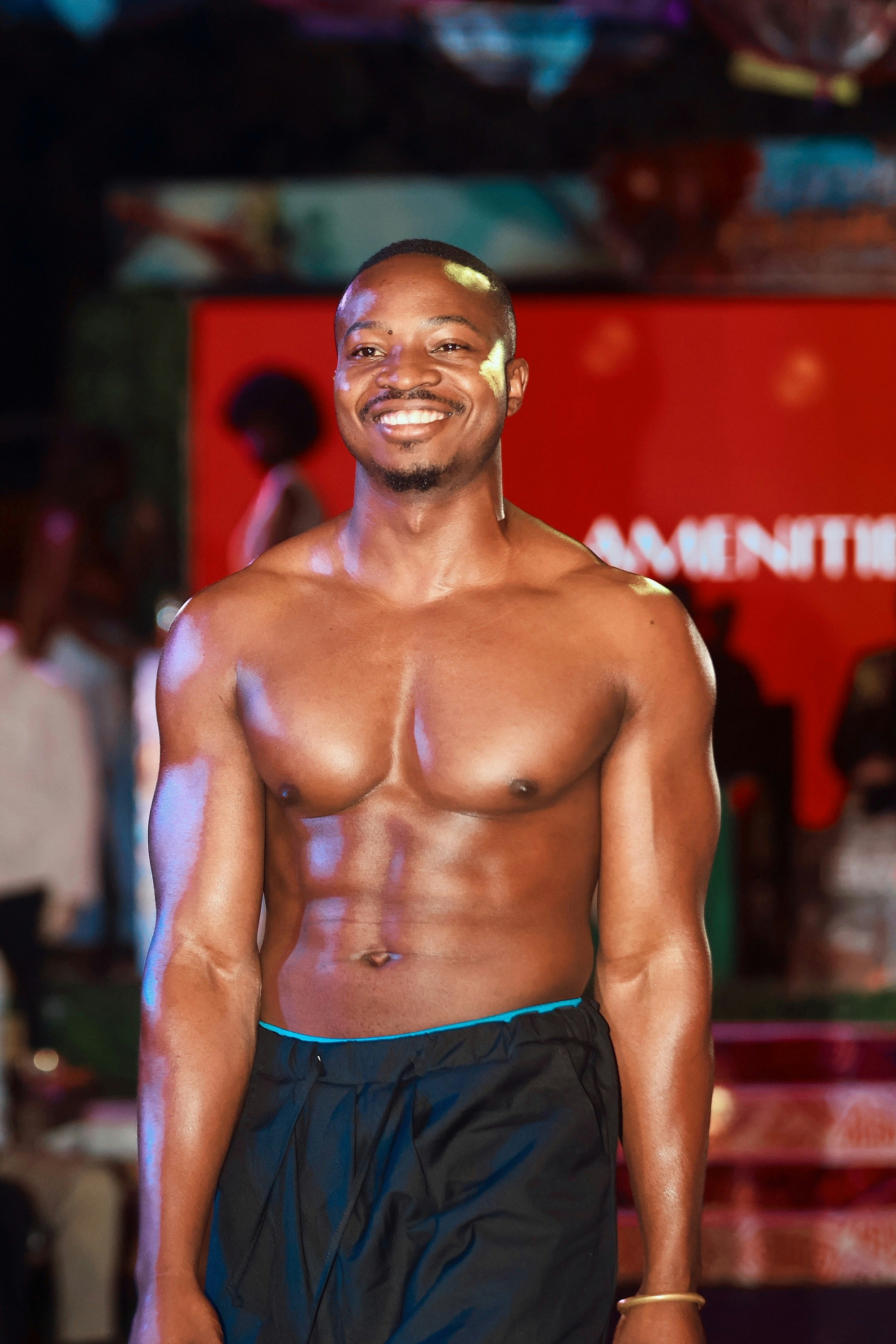 Confident Stride: A Shirtless Model Under Neon Lights