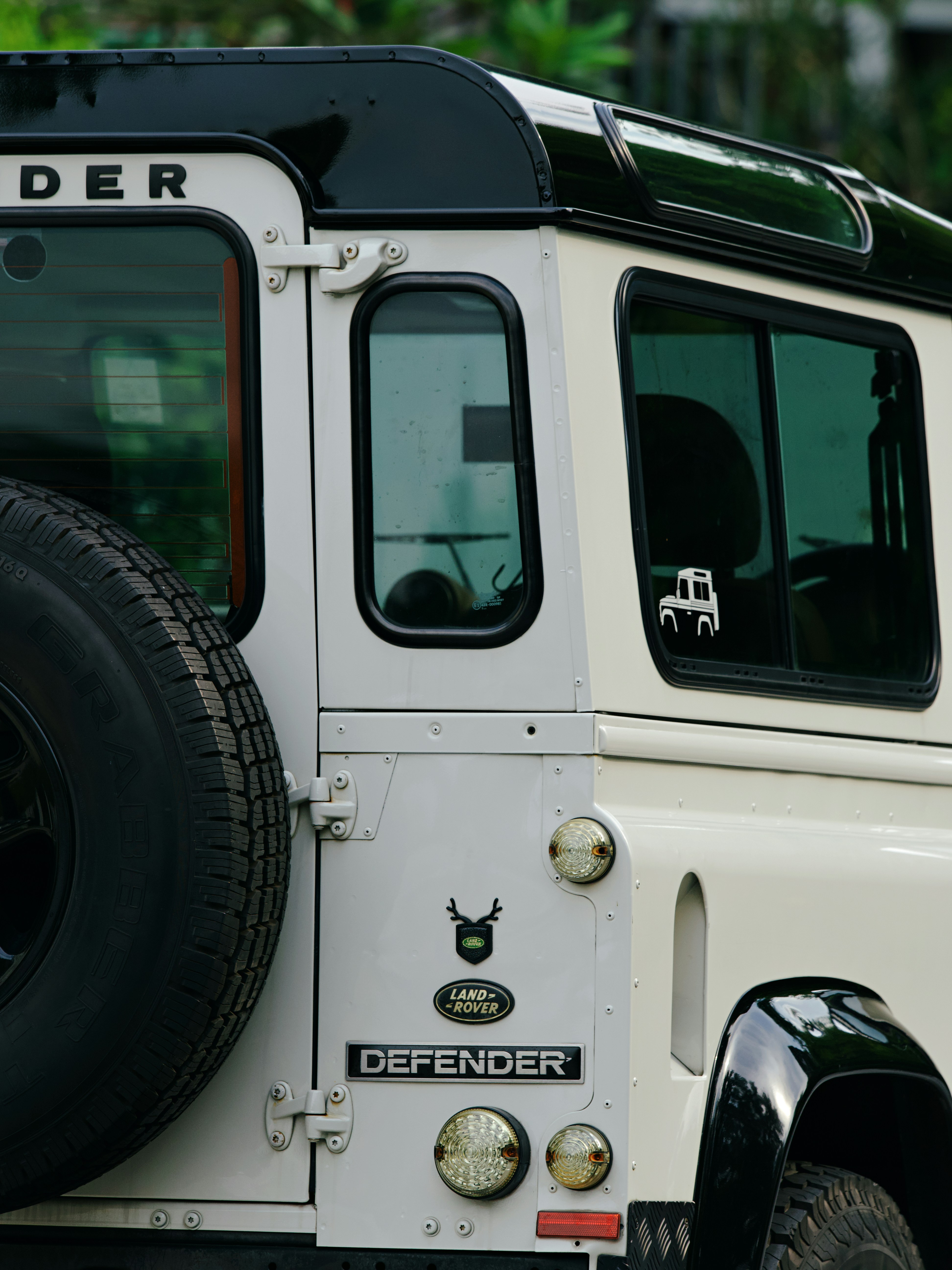 Rear-Quarter of a Defender: Spare Tire, Badges, and Window Sticker Tale