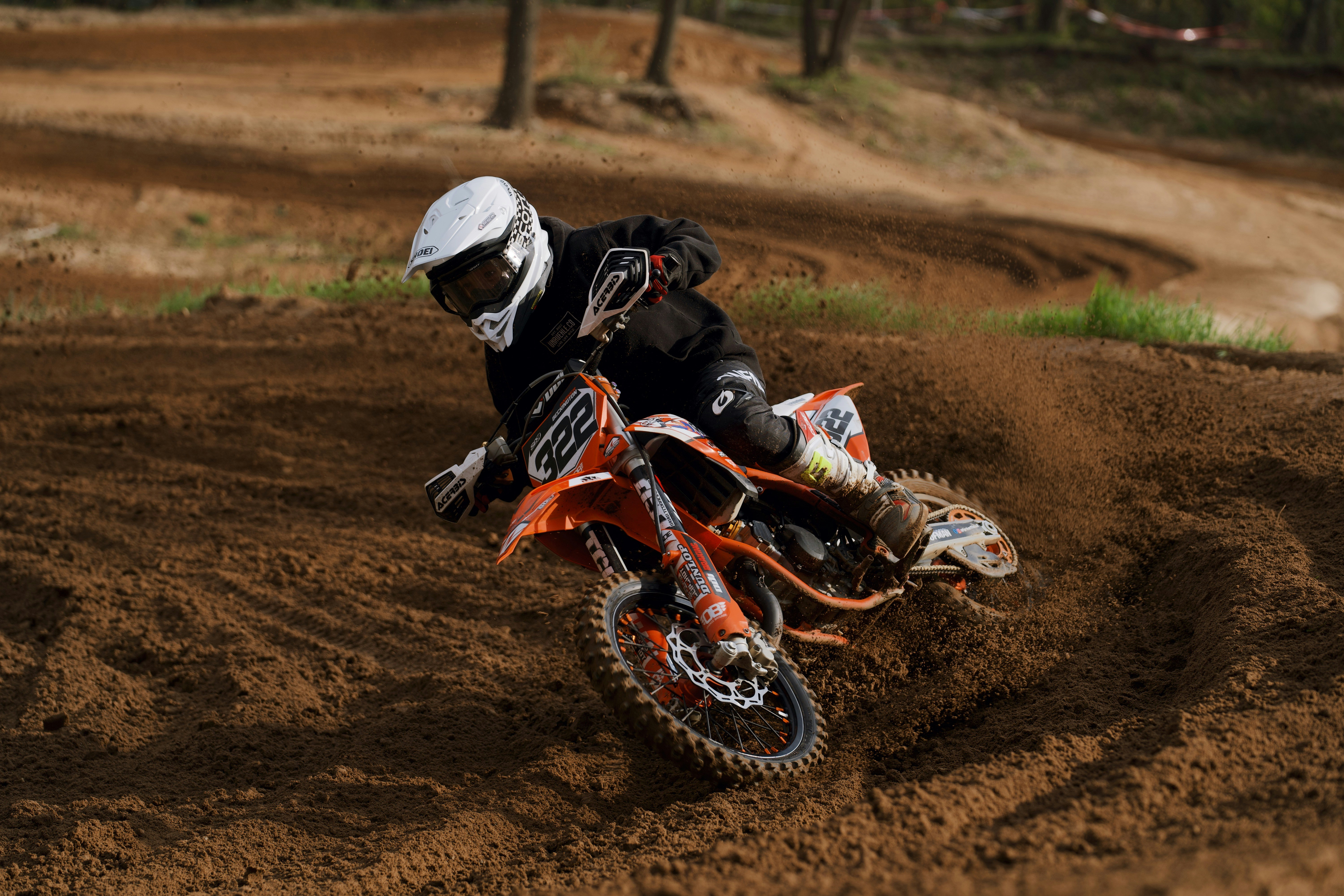 Rider in Control: Slope Turn Through Dust on a Dirt Track