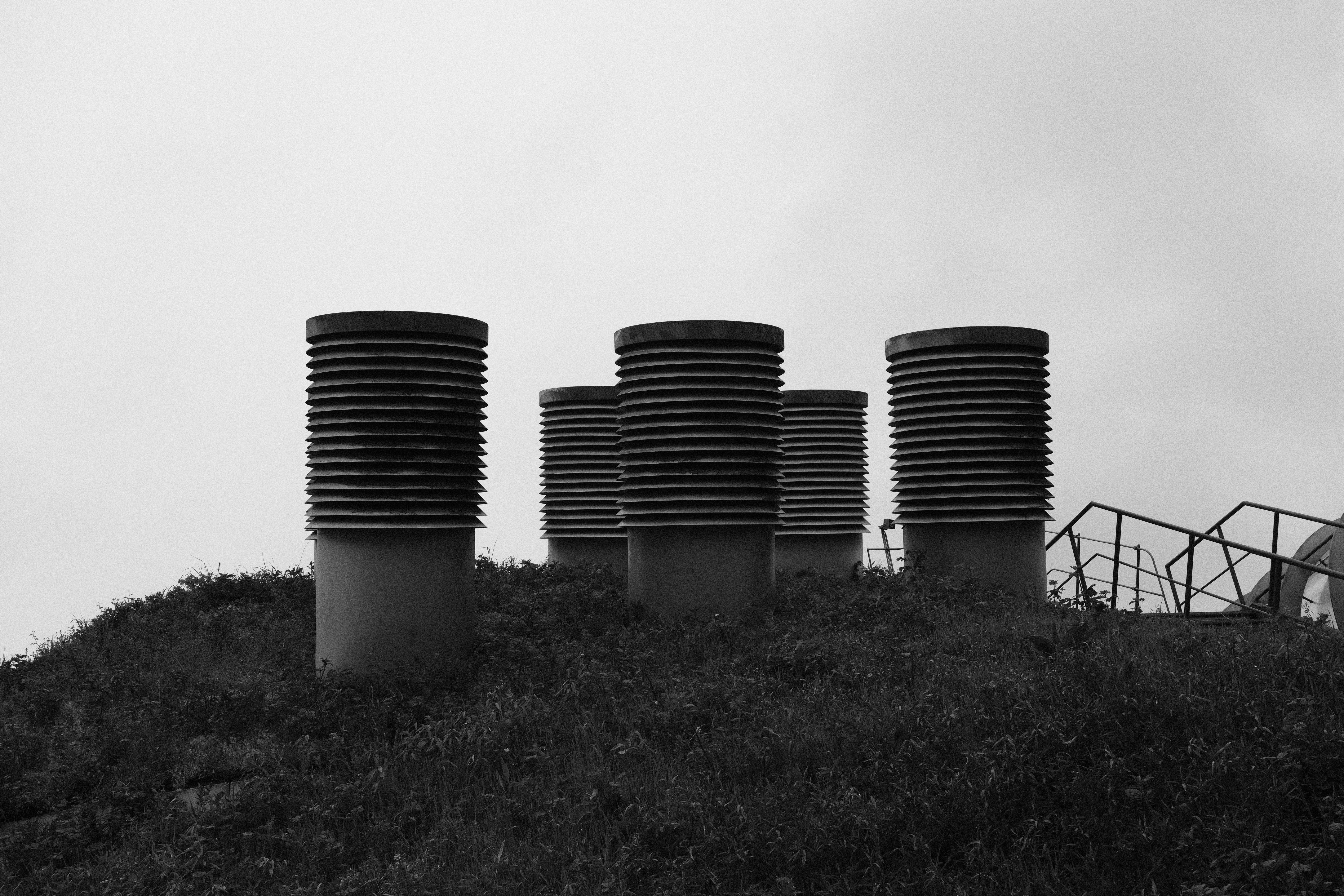 Ventilated Silhouette: A Row of Industrial Cores on a Quiet Hill