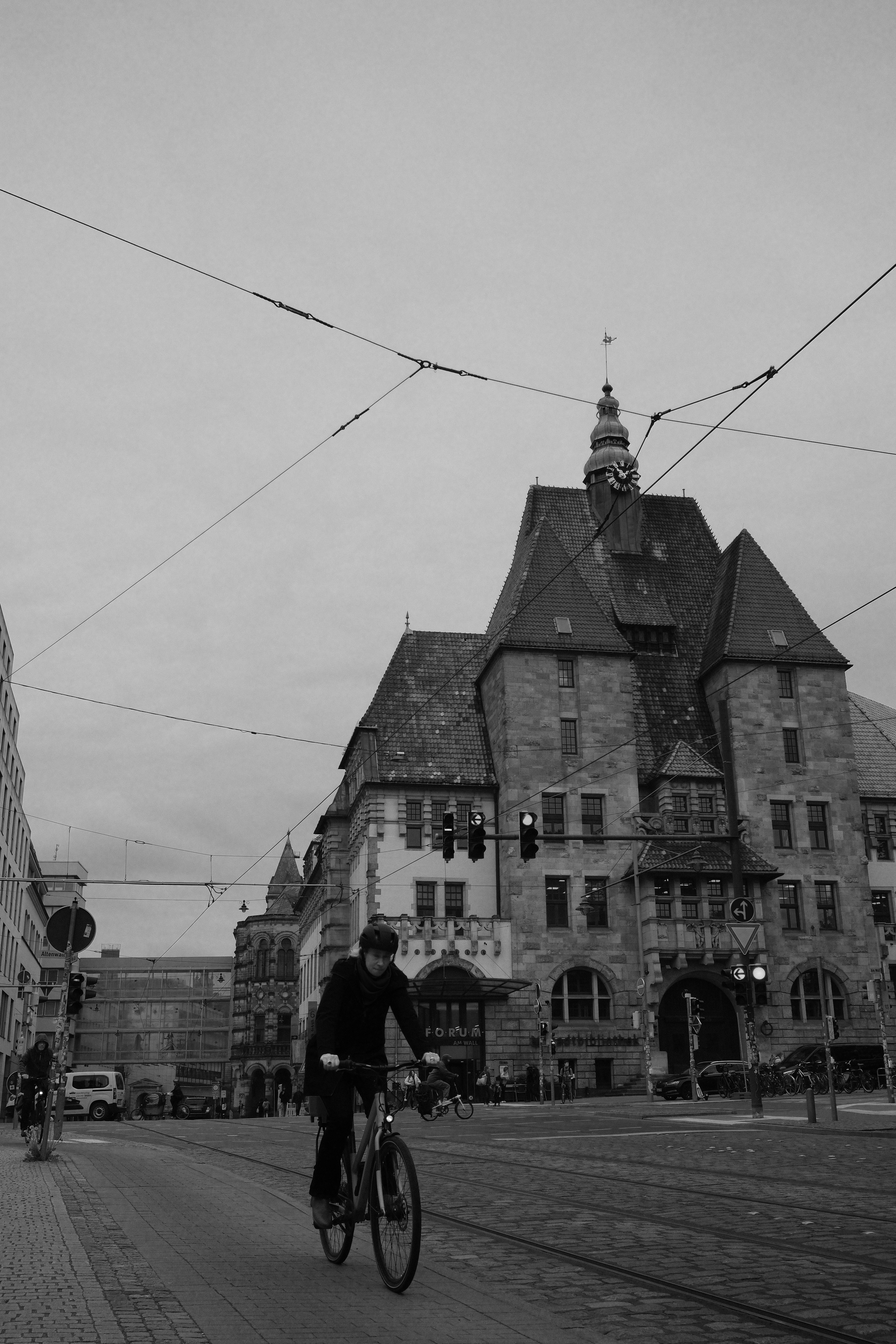 Pedestrian on a Cobblestone Street Beneath Historic Facades