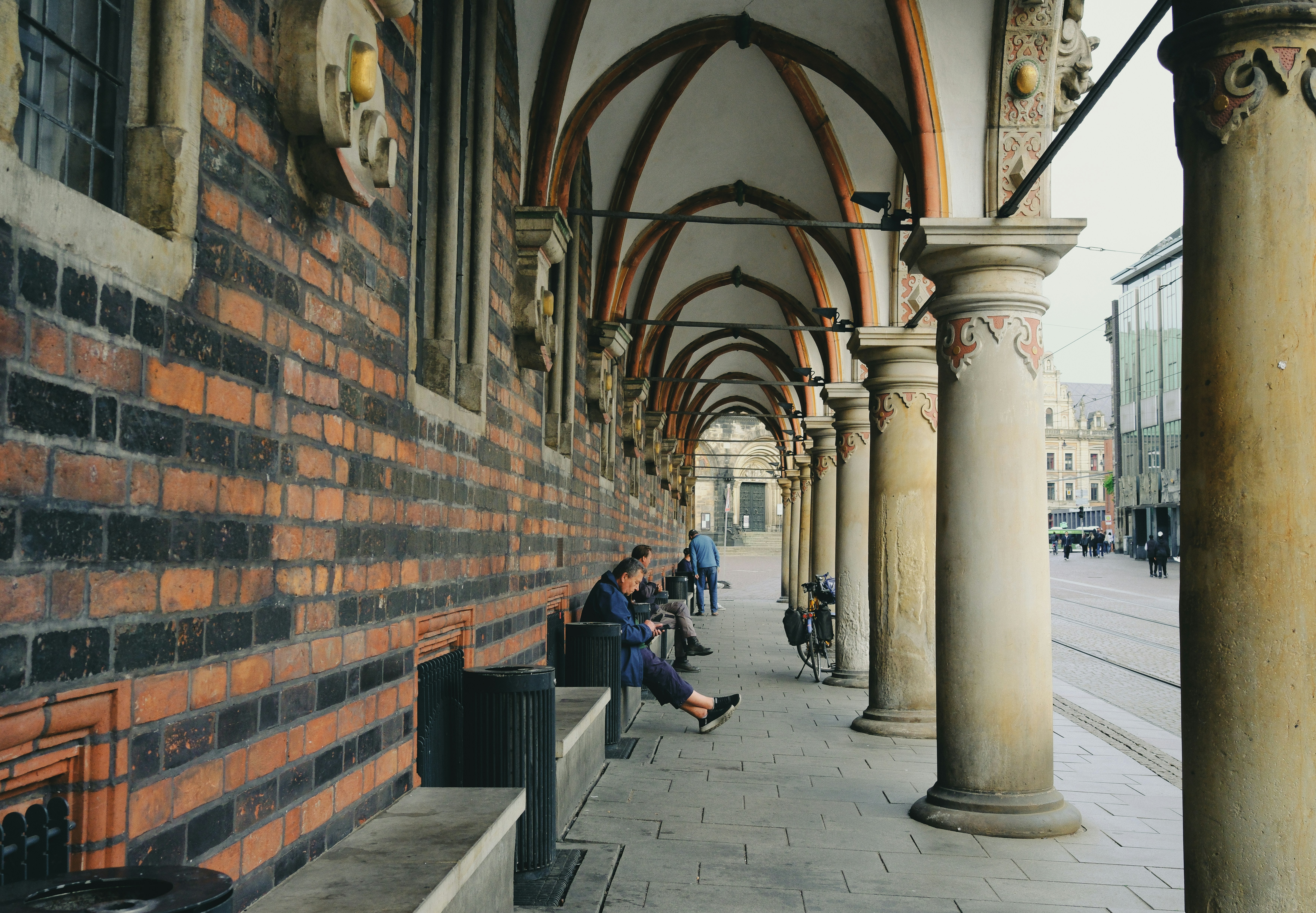 Arcade of Quiet Pedestrians along a Brick-Arcaded Promenade