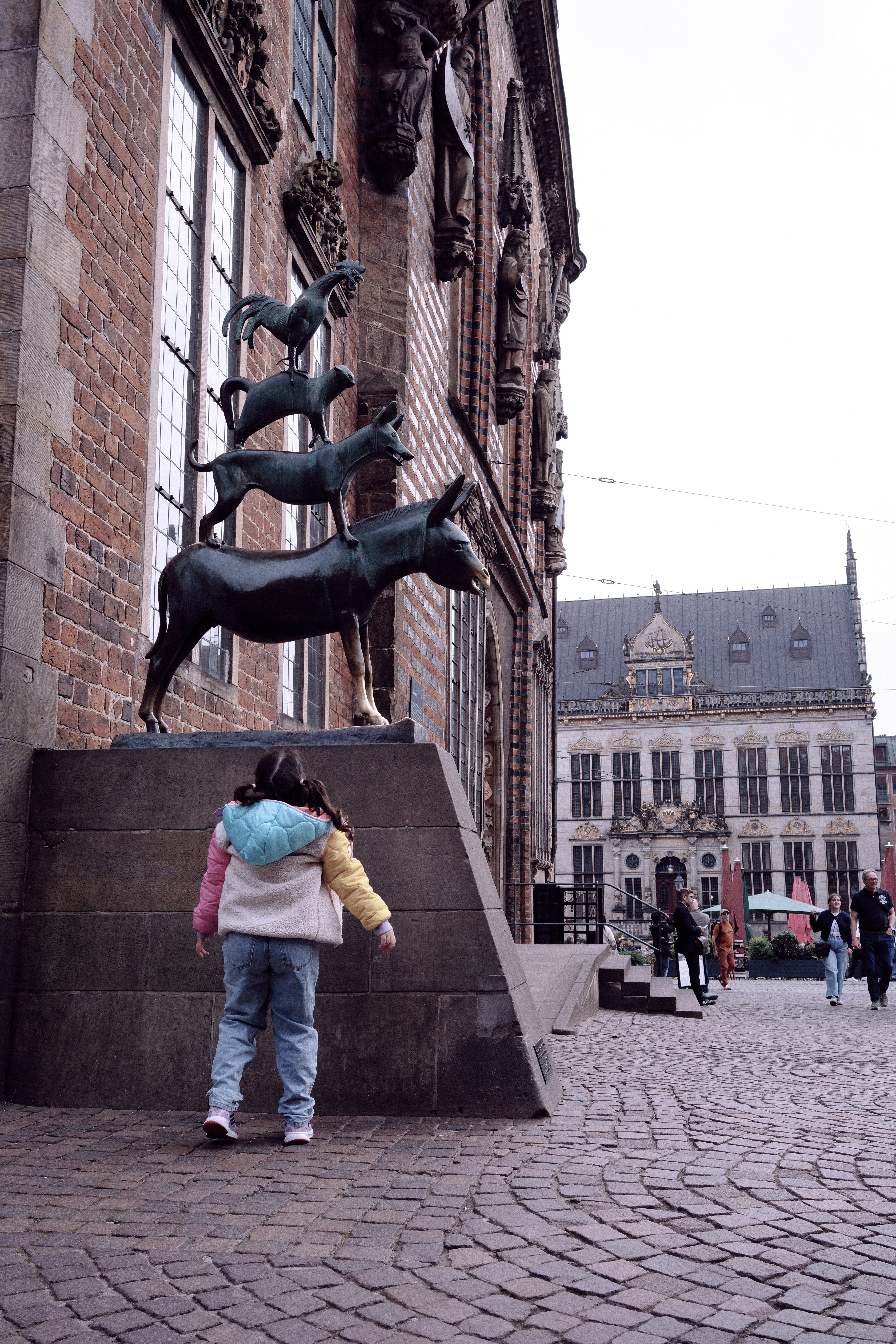 Balancing Act: A child approaches the bronze canine column