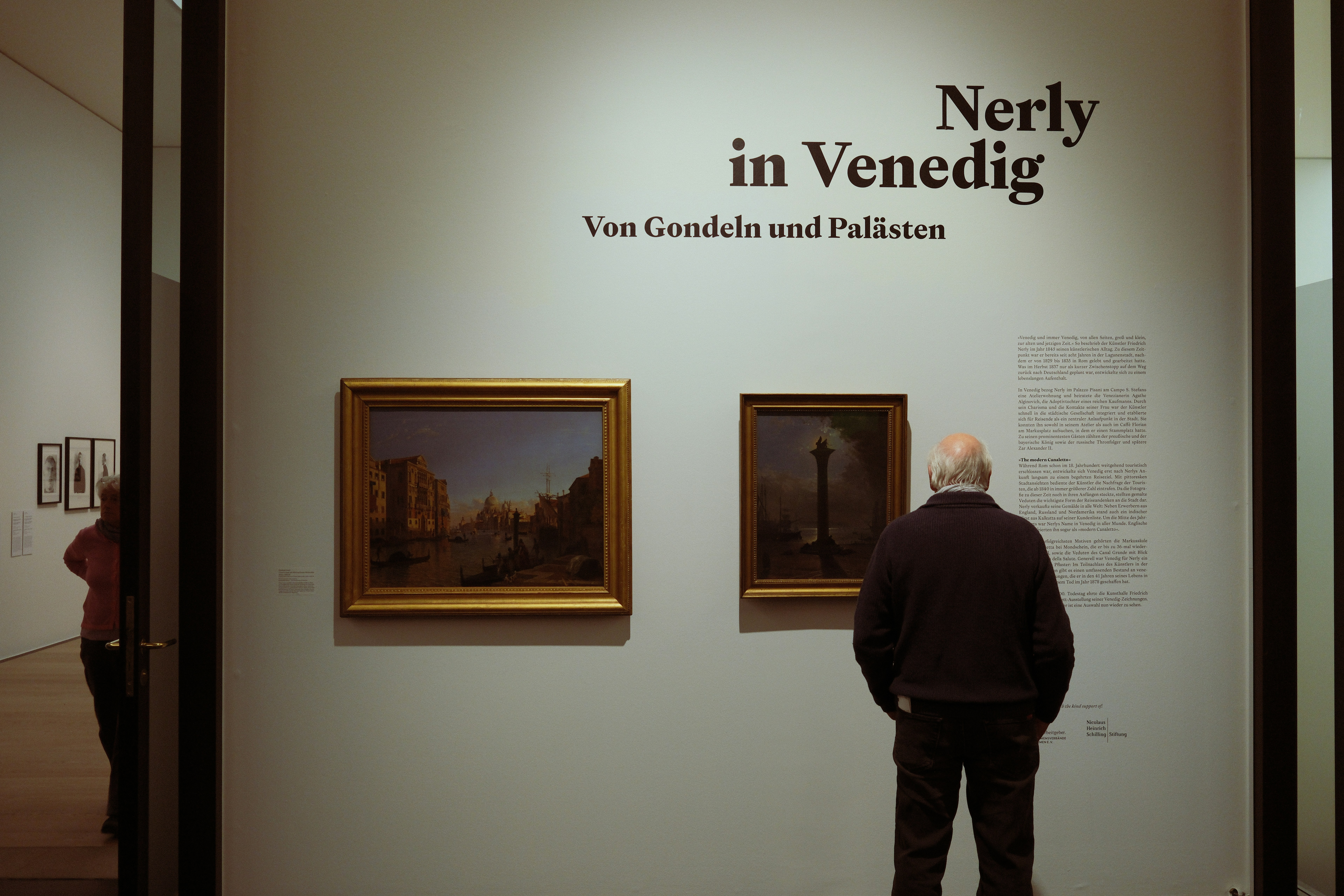 Visitor in the Gallery appraises a quiet pair of Venetian scenes