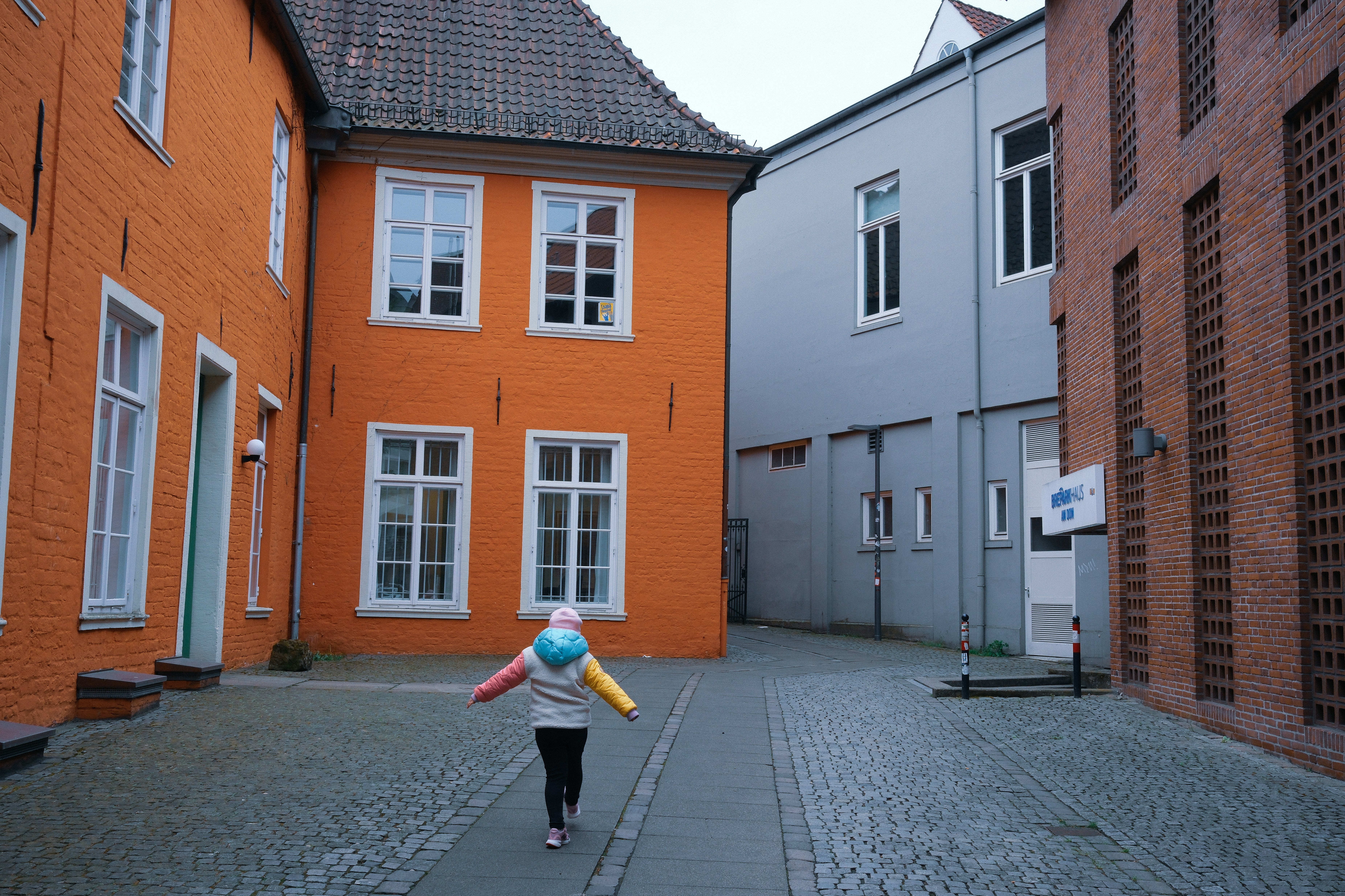 Child in Colorful Courtyard: A Quiet Street Run