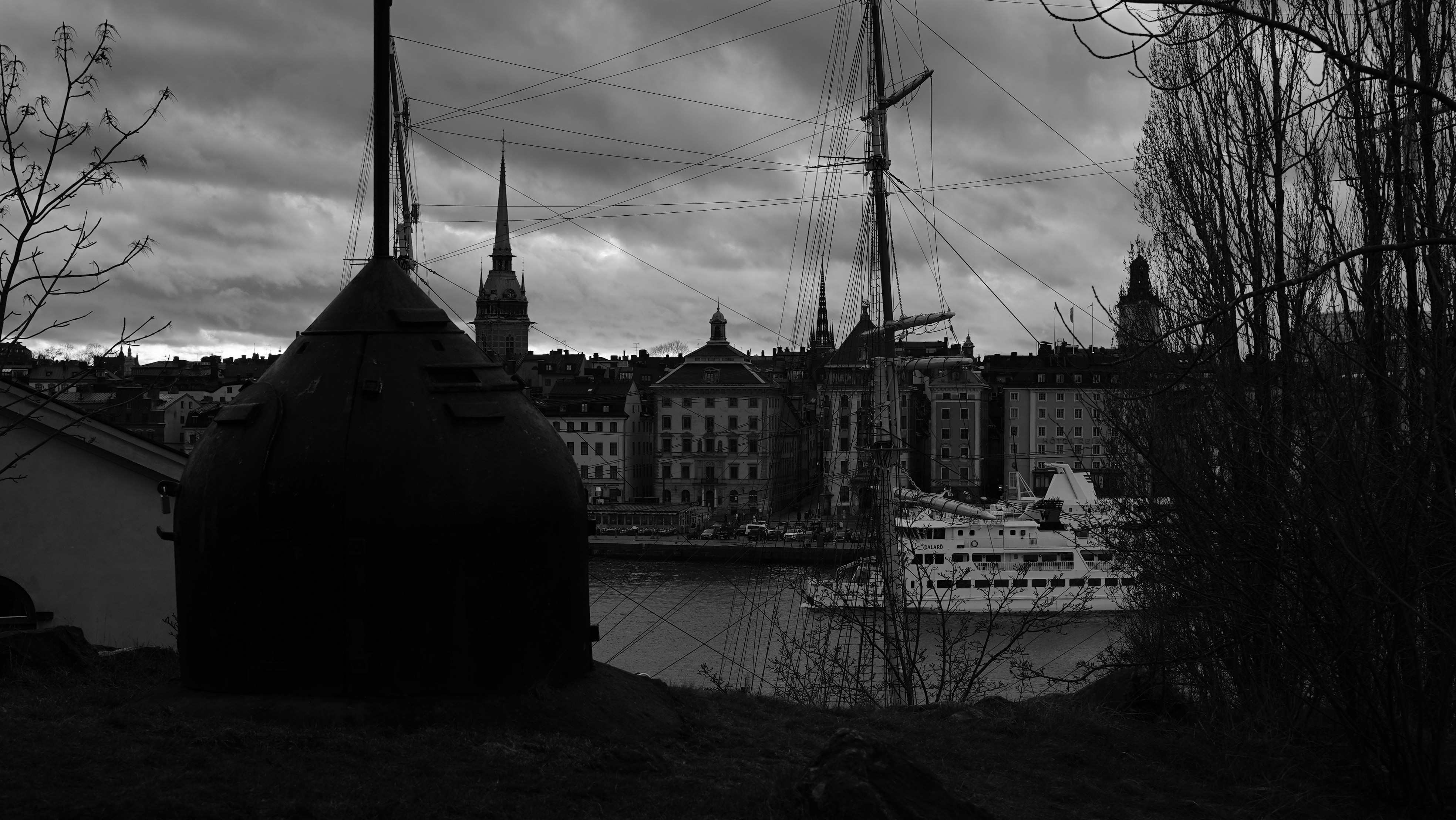 Harbor silhouette at dusk: masted skyline over calm water